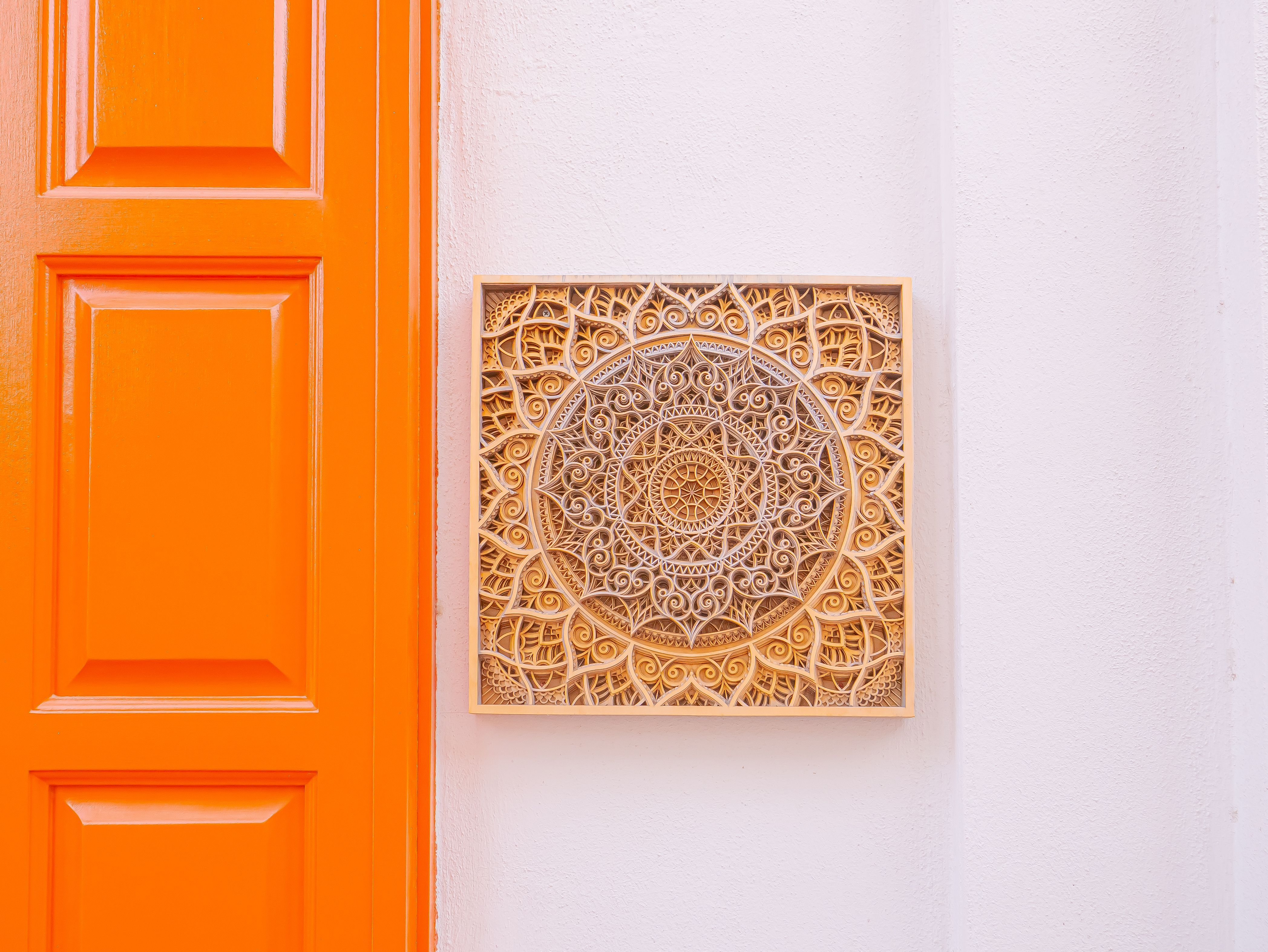 Vibrant Orange Door with Intricate Wall Art · Free Stock Photo