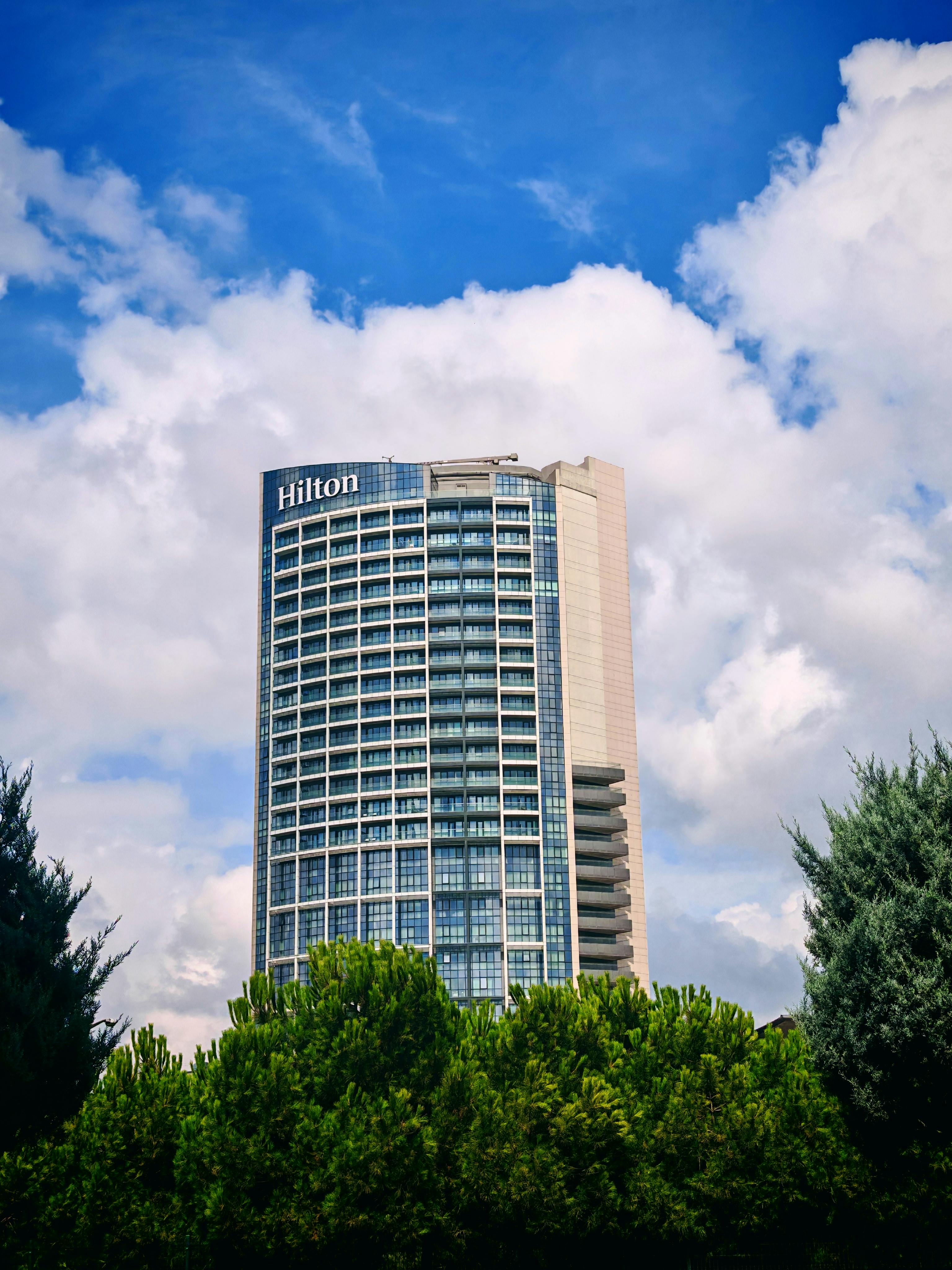 Modern Hilton Hotel Tower against Blue Sky · Free Stock Photo