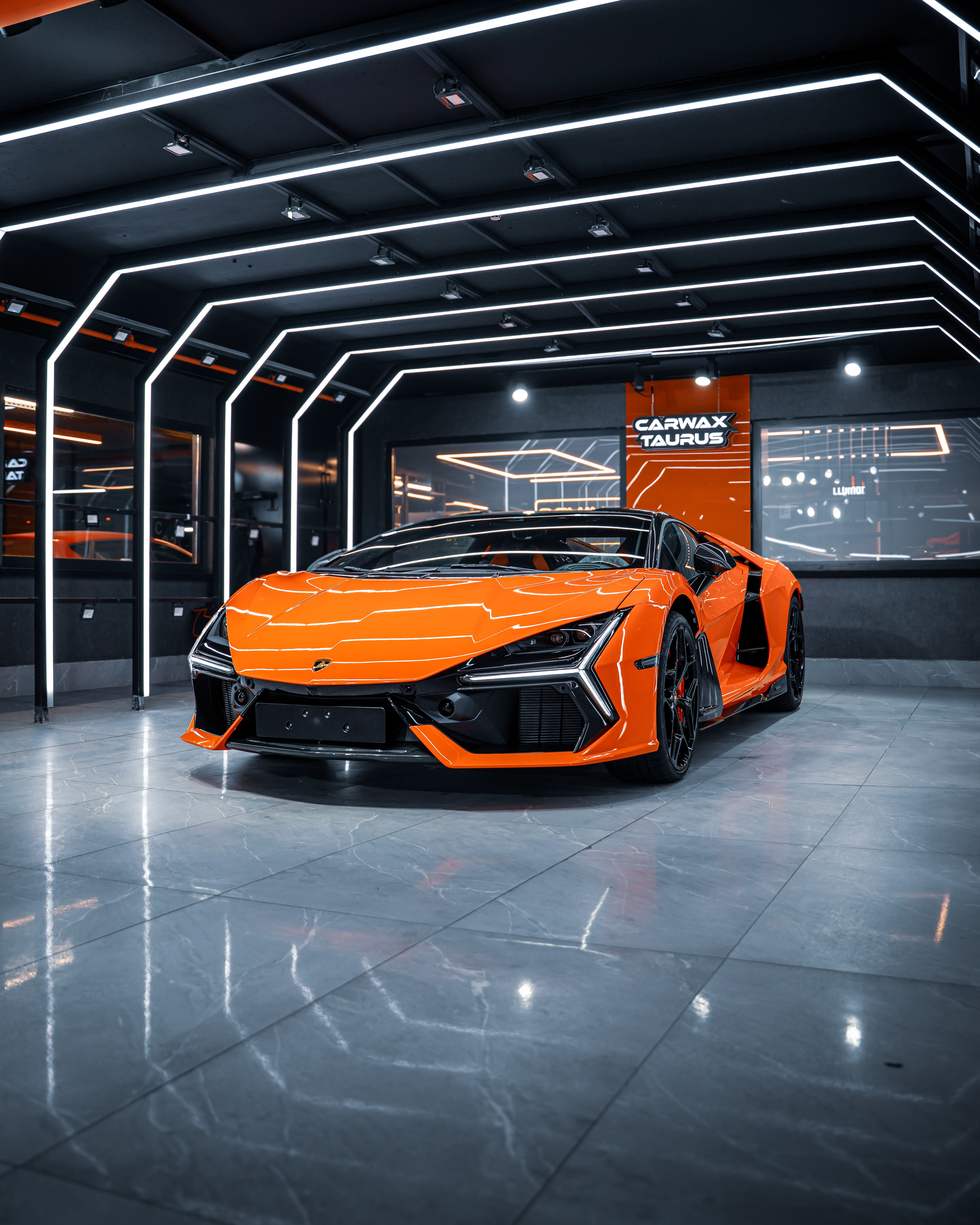 Sleek Orange Sports Car in Modern Showroom · Free Stock Photo
