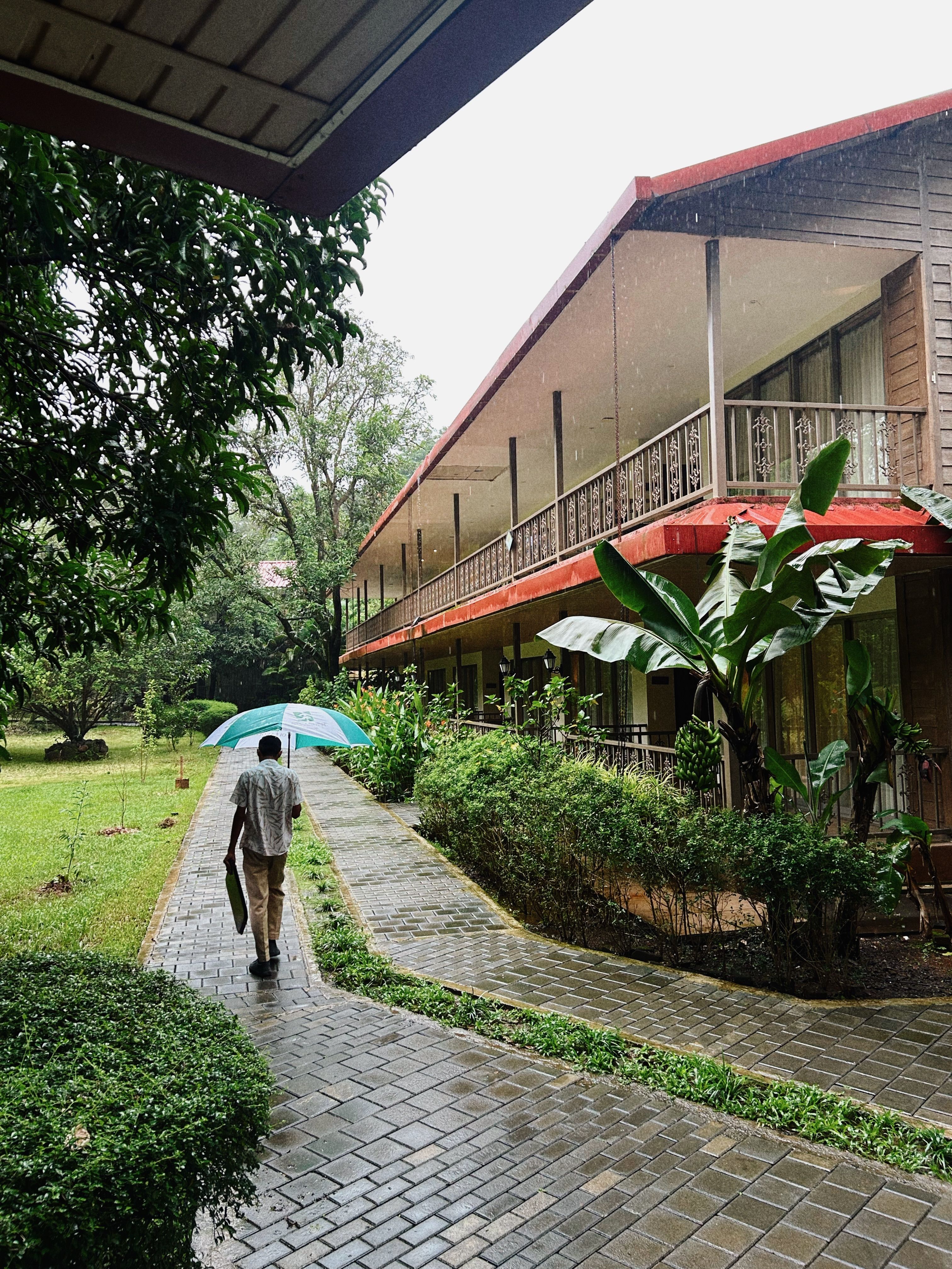 Rainy Day Walk Along Modern Building Pathway · Free Stock Photo