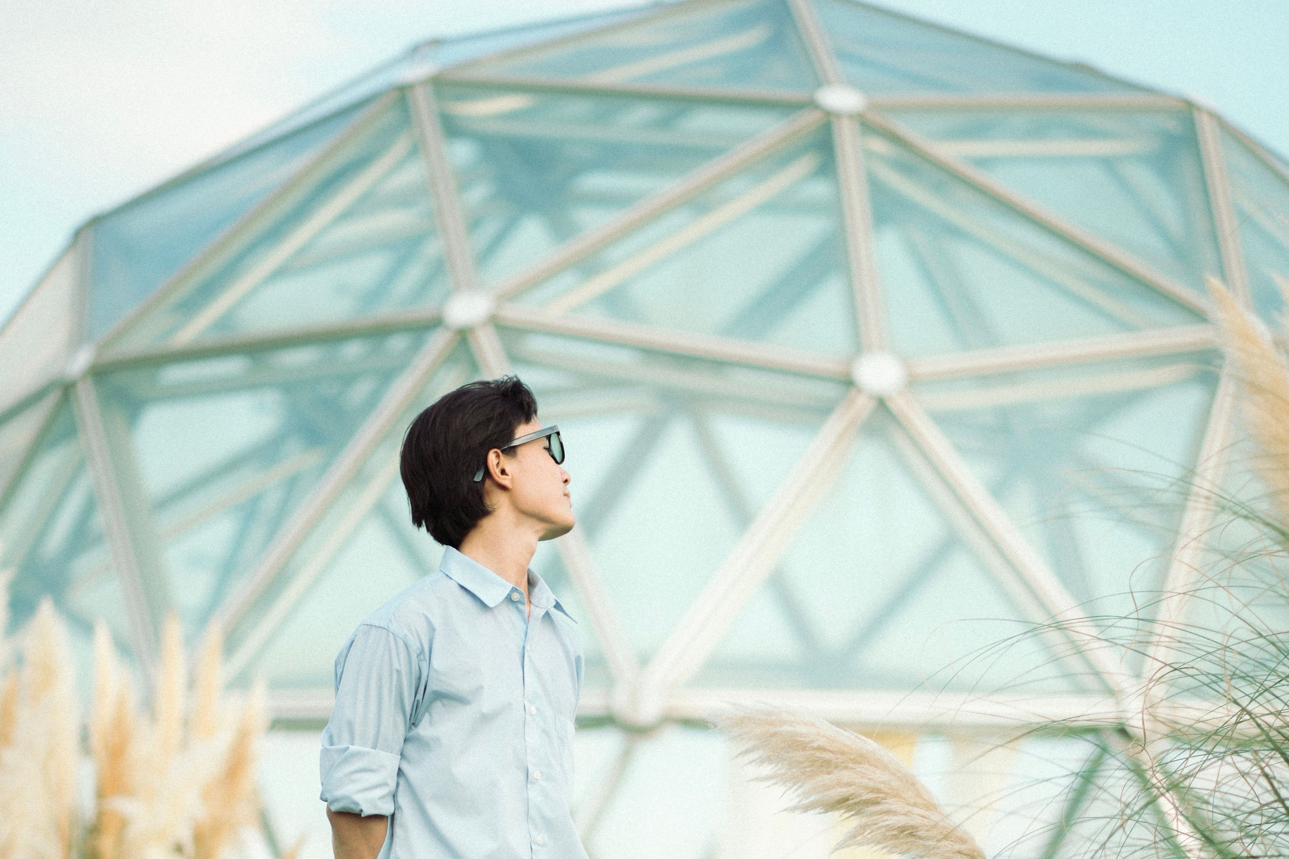 Person in front of geodesic glass dome structure · Free Stock Photo