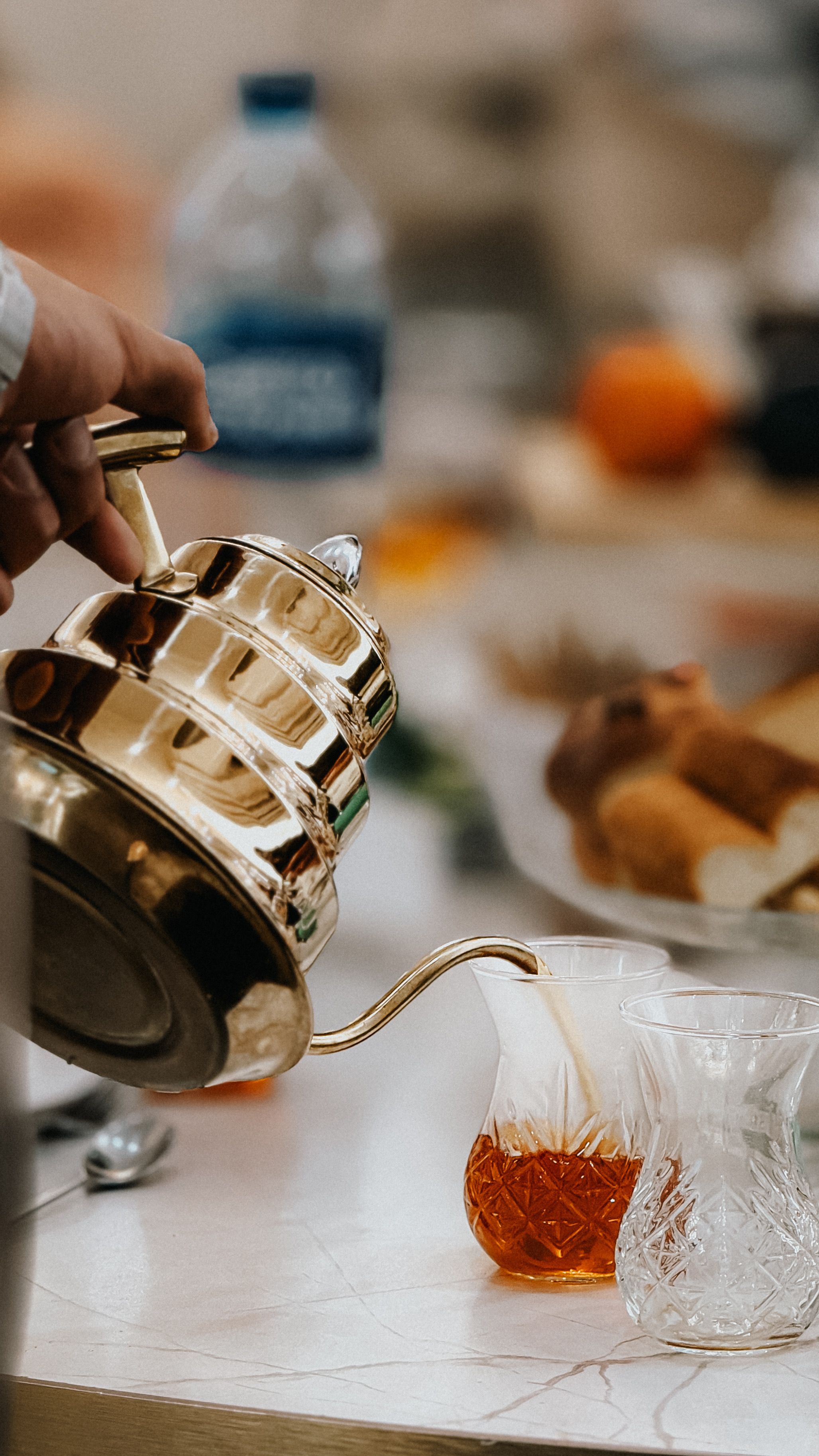 Pouring Tea with a Brass Kettle in an Elegant Setting · Free Stock Photo