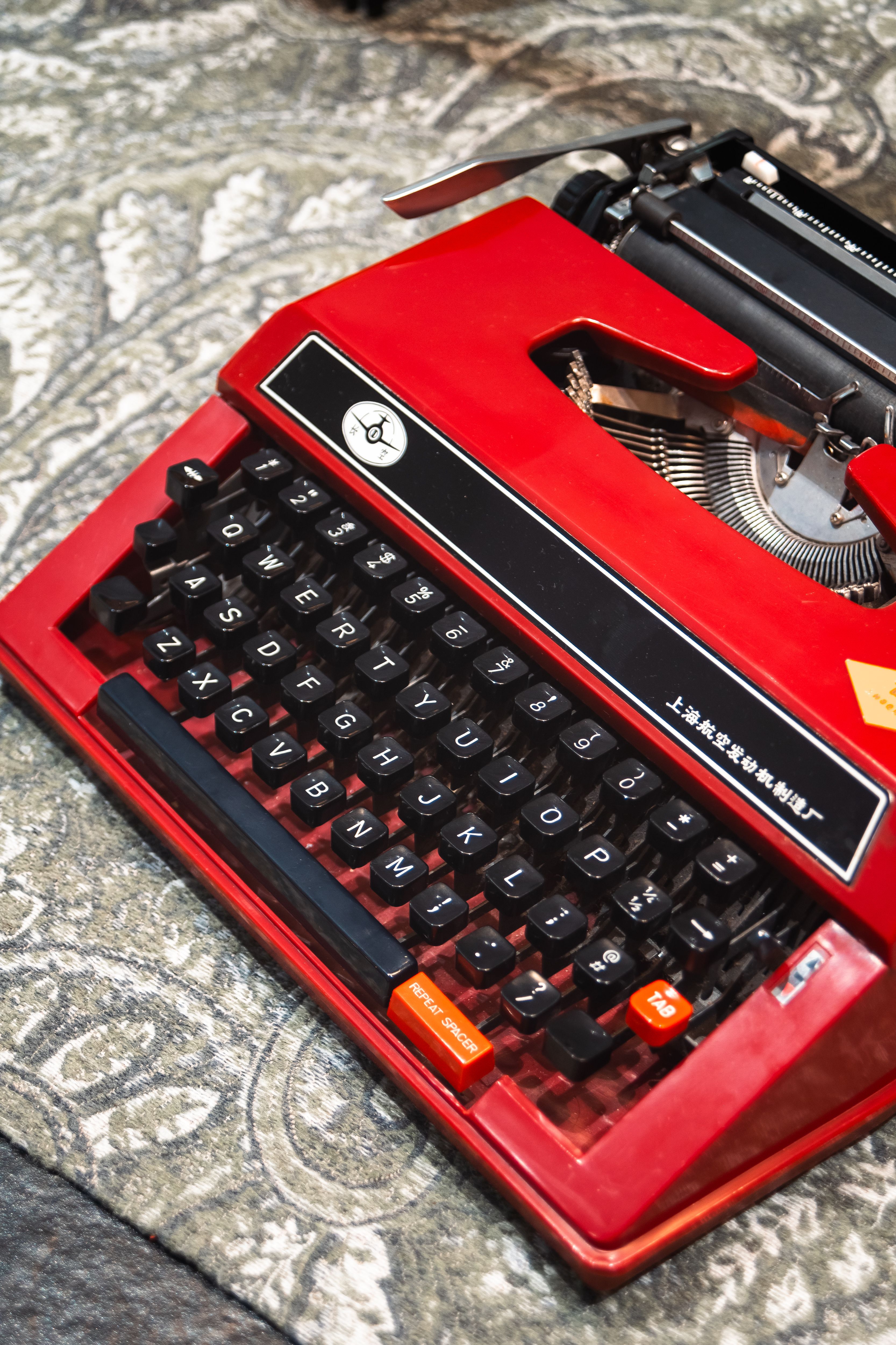 Red Vintage Typewriter on Patterned Fabric · Free Stock Photo