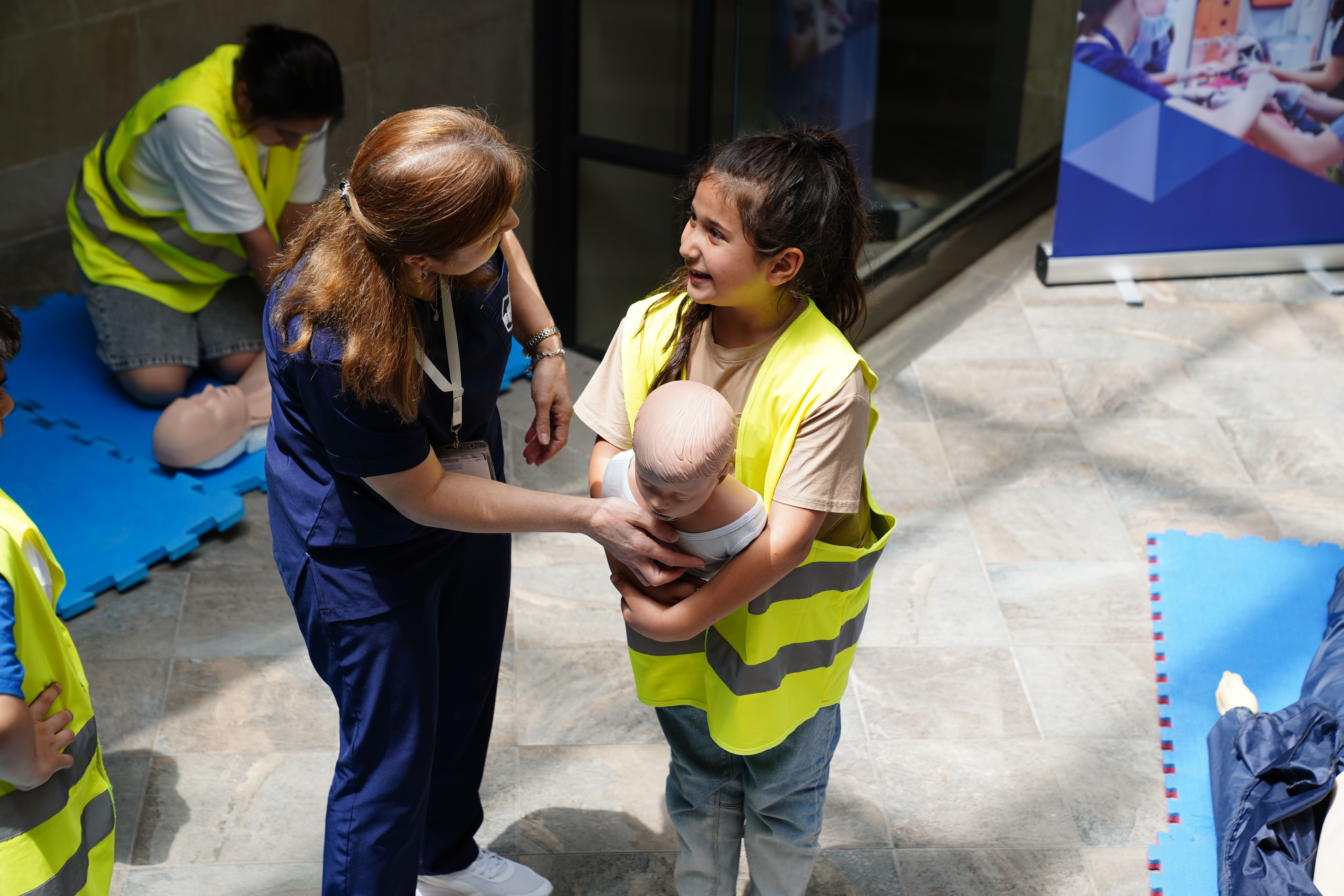 Child Learning First Aid Techniques with Instructor · Free Stock Photo