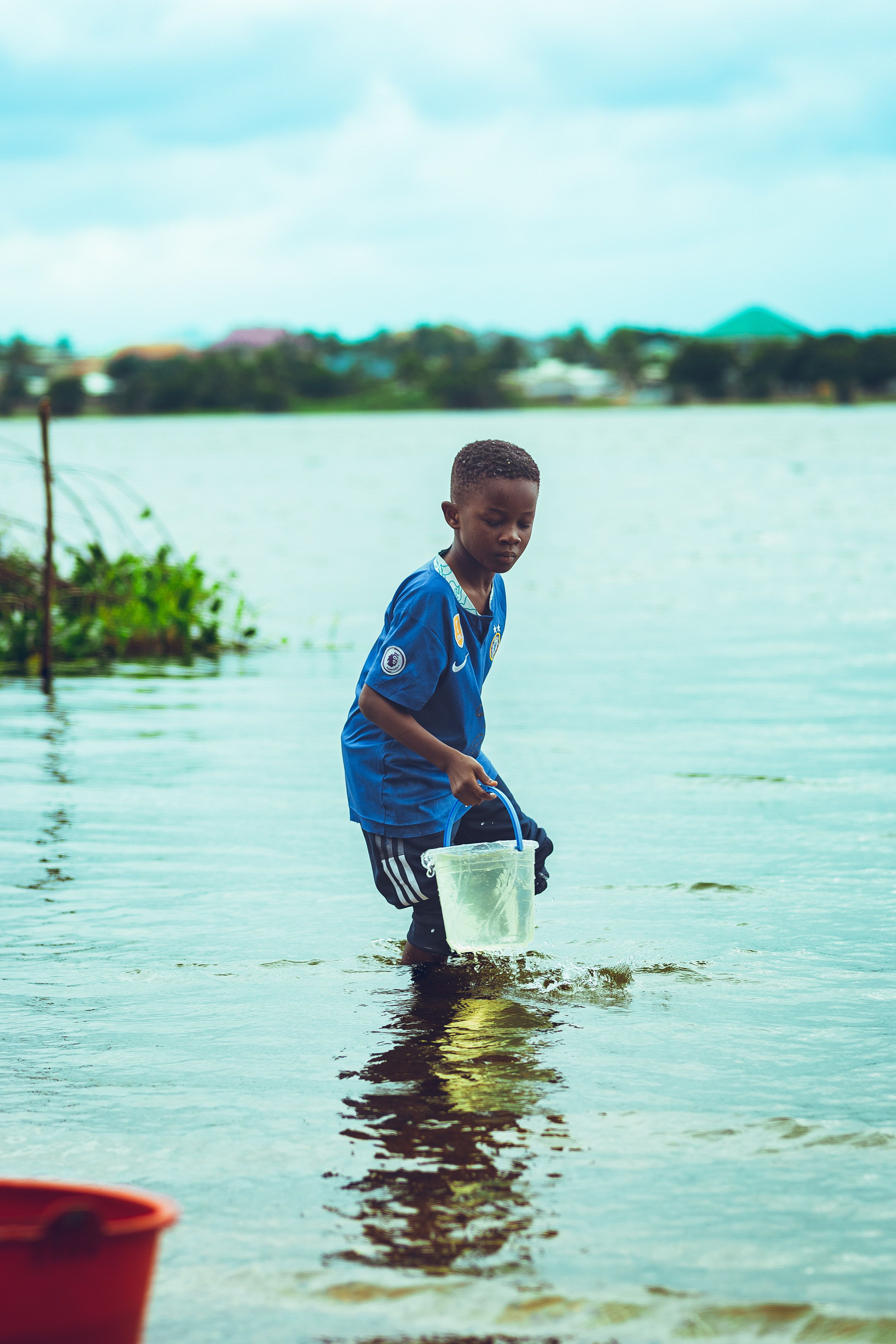Child Collecting Water by the Lakeside in Accra · Free Stock Photo