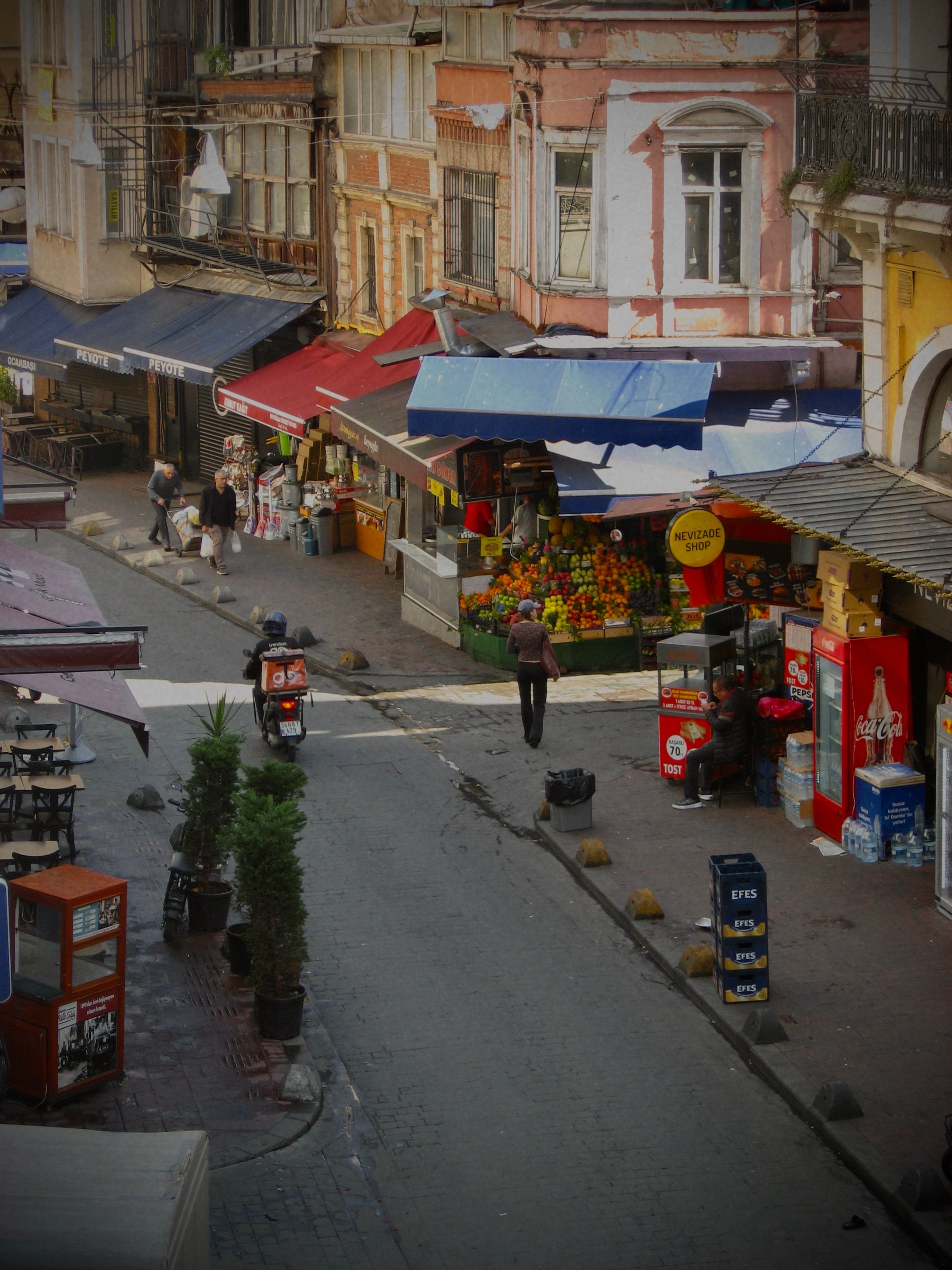 Bustling European Market Street with Shops and Cafes · Free Stock Photo