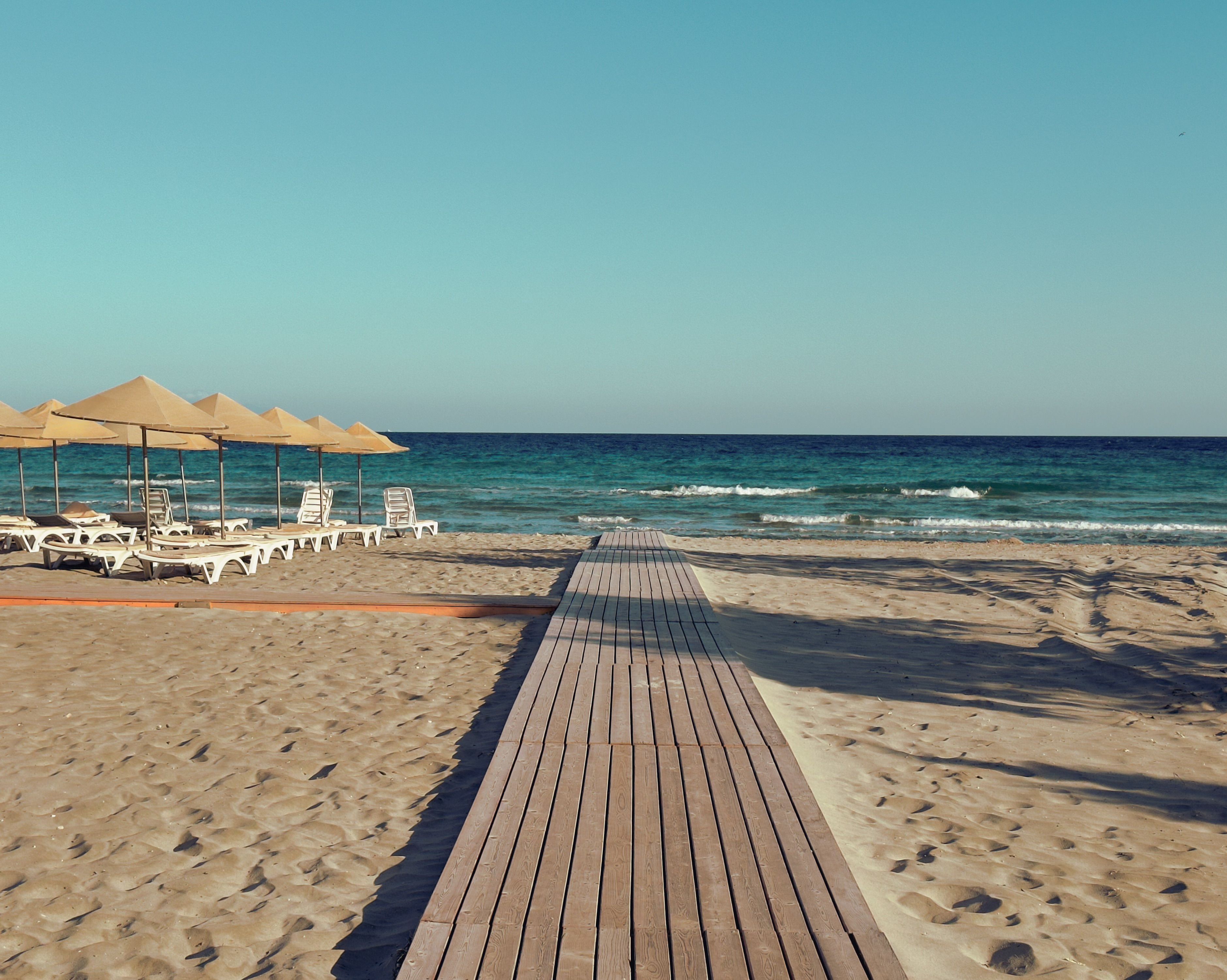 Sunny Beachfront with Parasols and Boardwalk in Turkey · Free Stock Photo