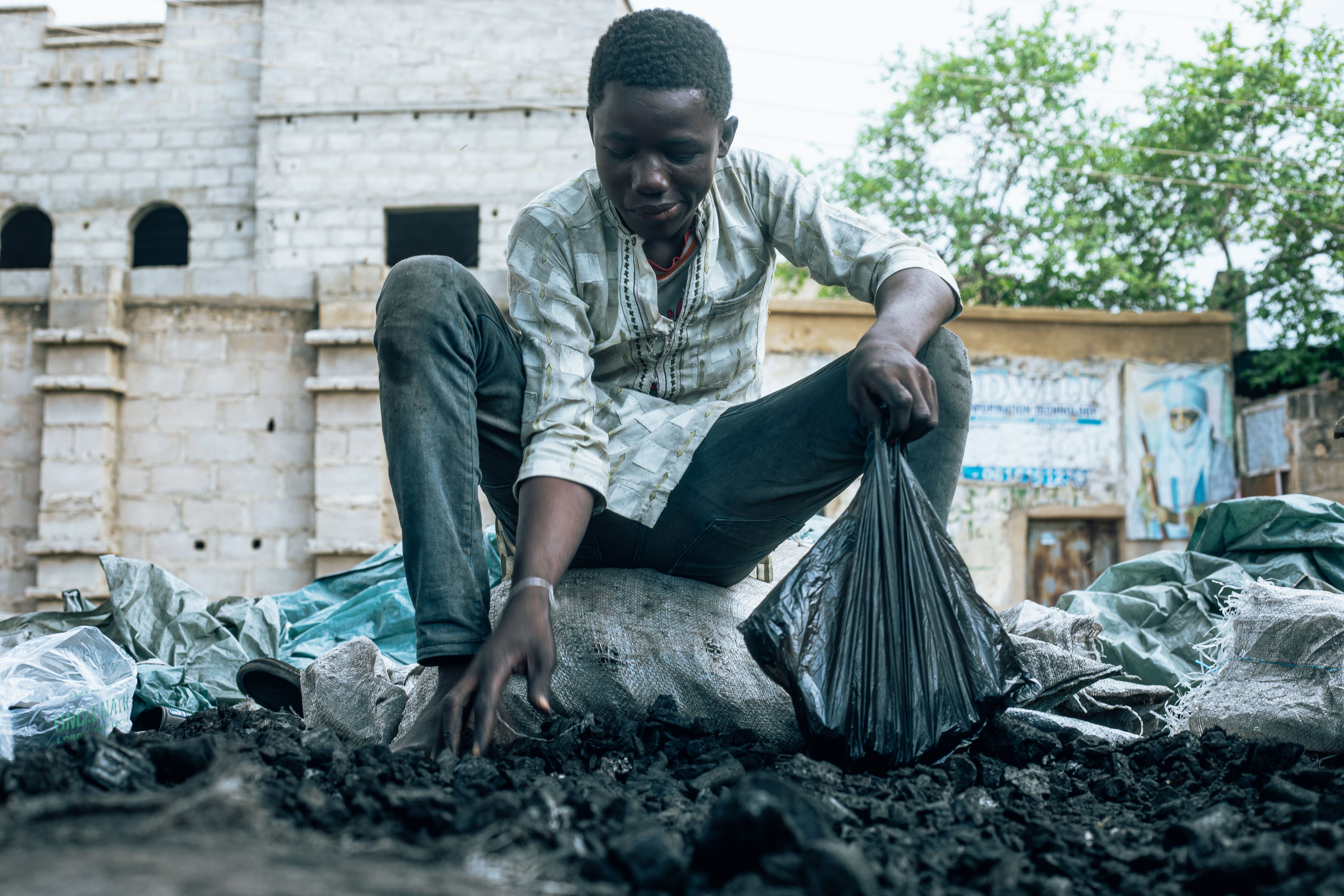 Young Man Working with Coal Outdoors in Village · Free Stock Photo