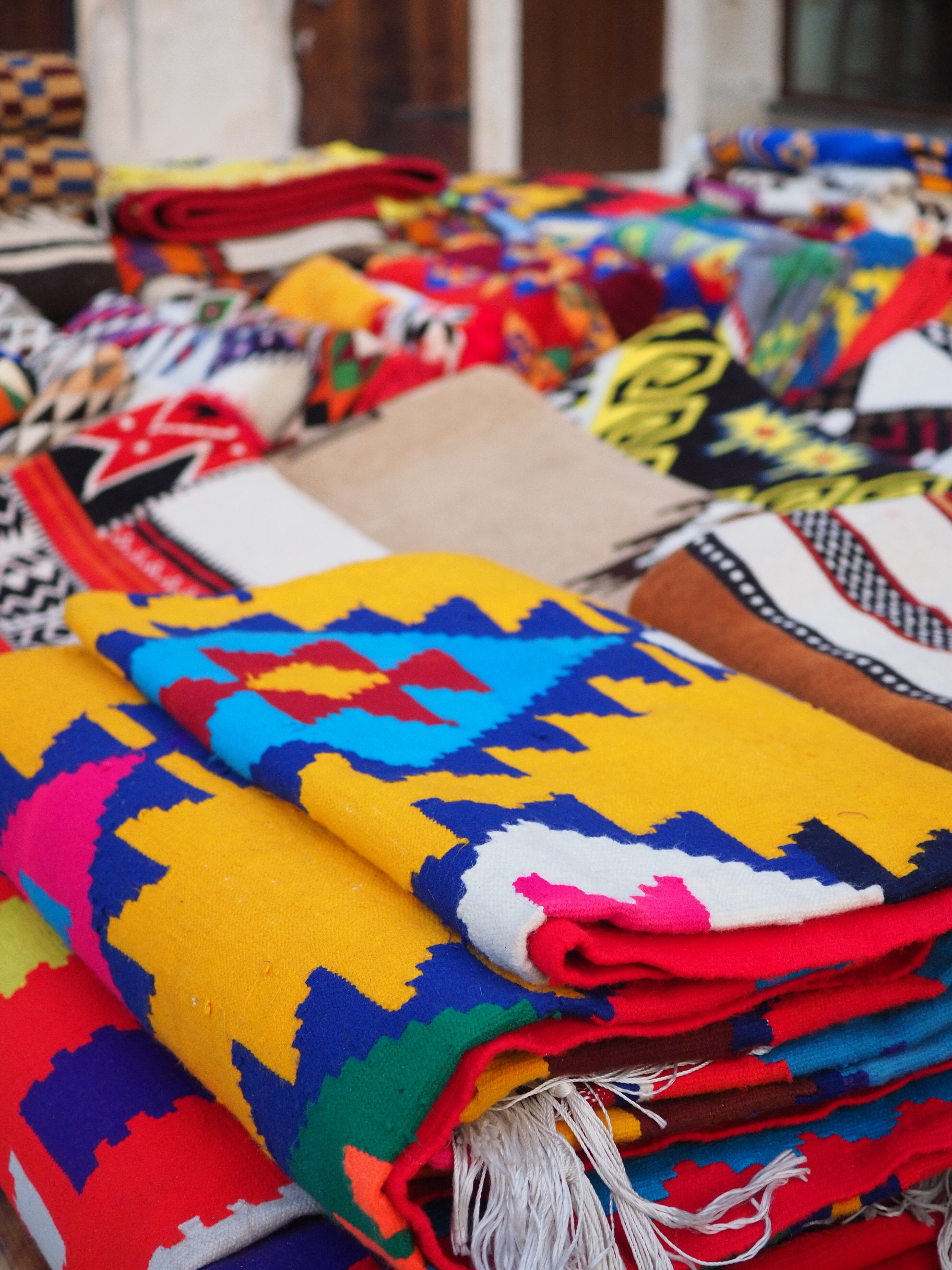 Vibrant Stacked Woven Rugs in Doha Market · Free Stock Photo