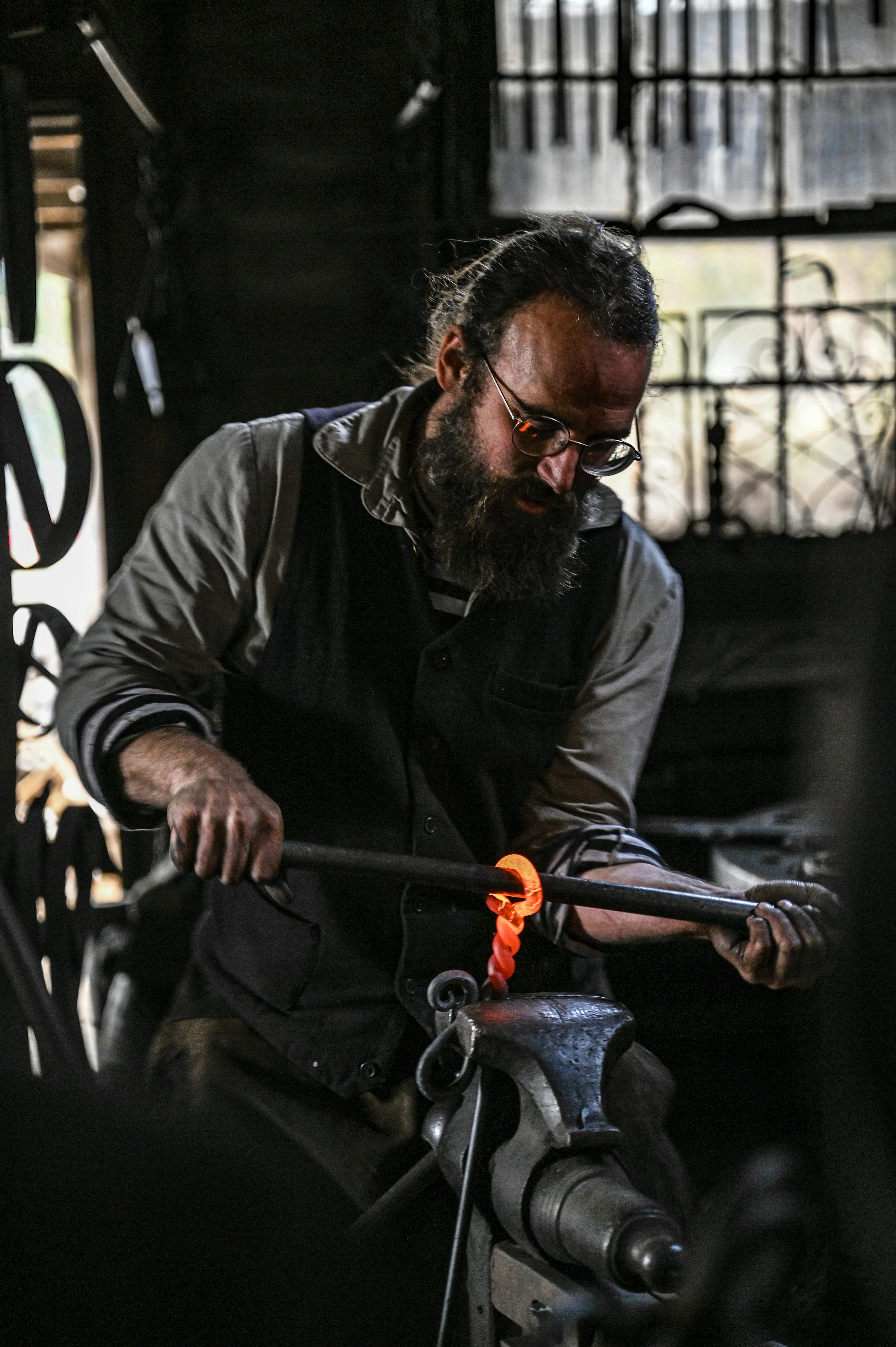 Skilled Blacksmith Forging Metal in Workshop · Free Stock Photo