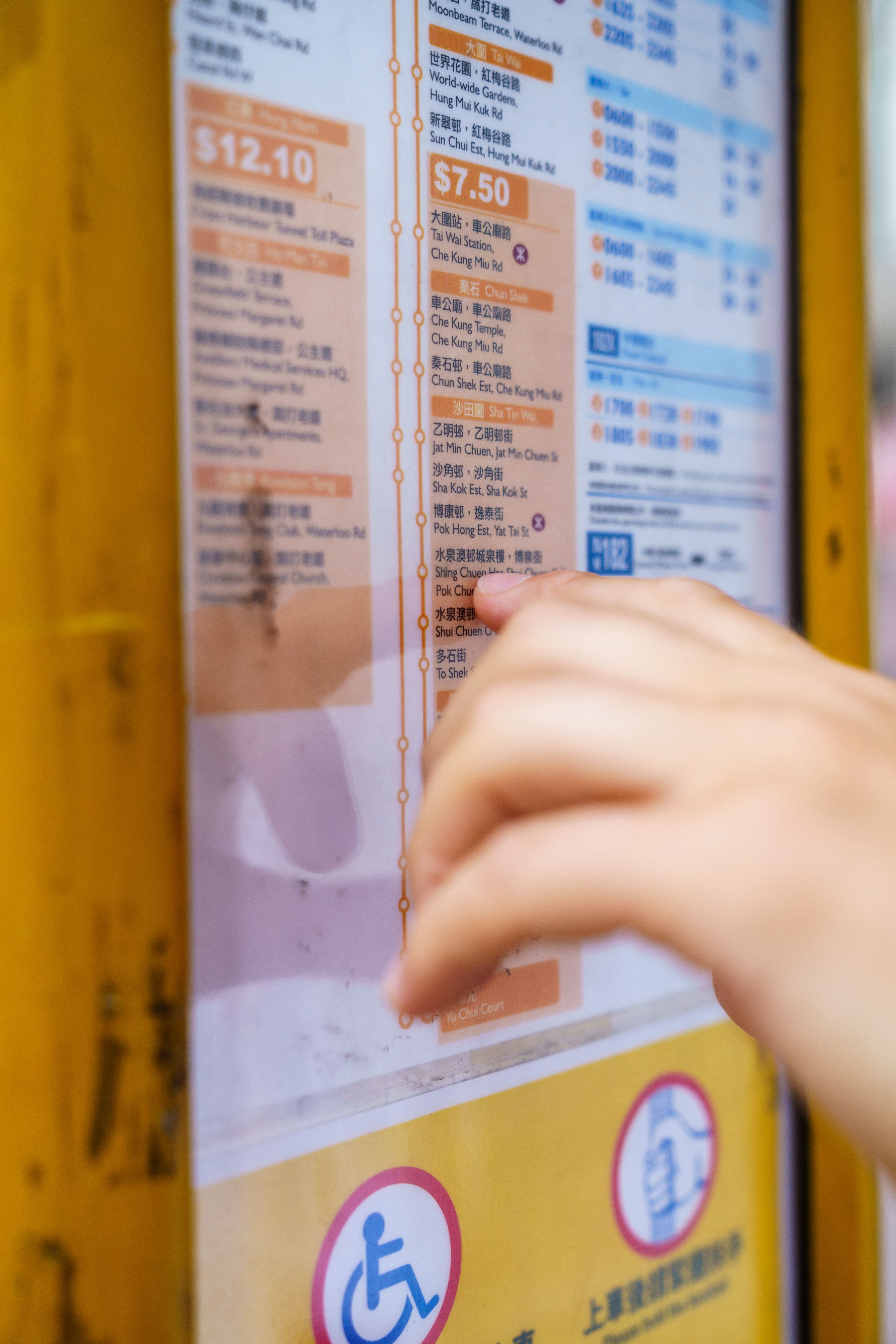 Close-up of Hand Reading Bus Stop Information Display · Free Stock Photo