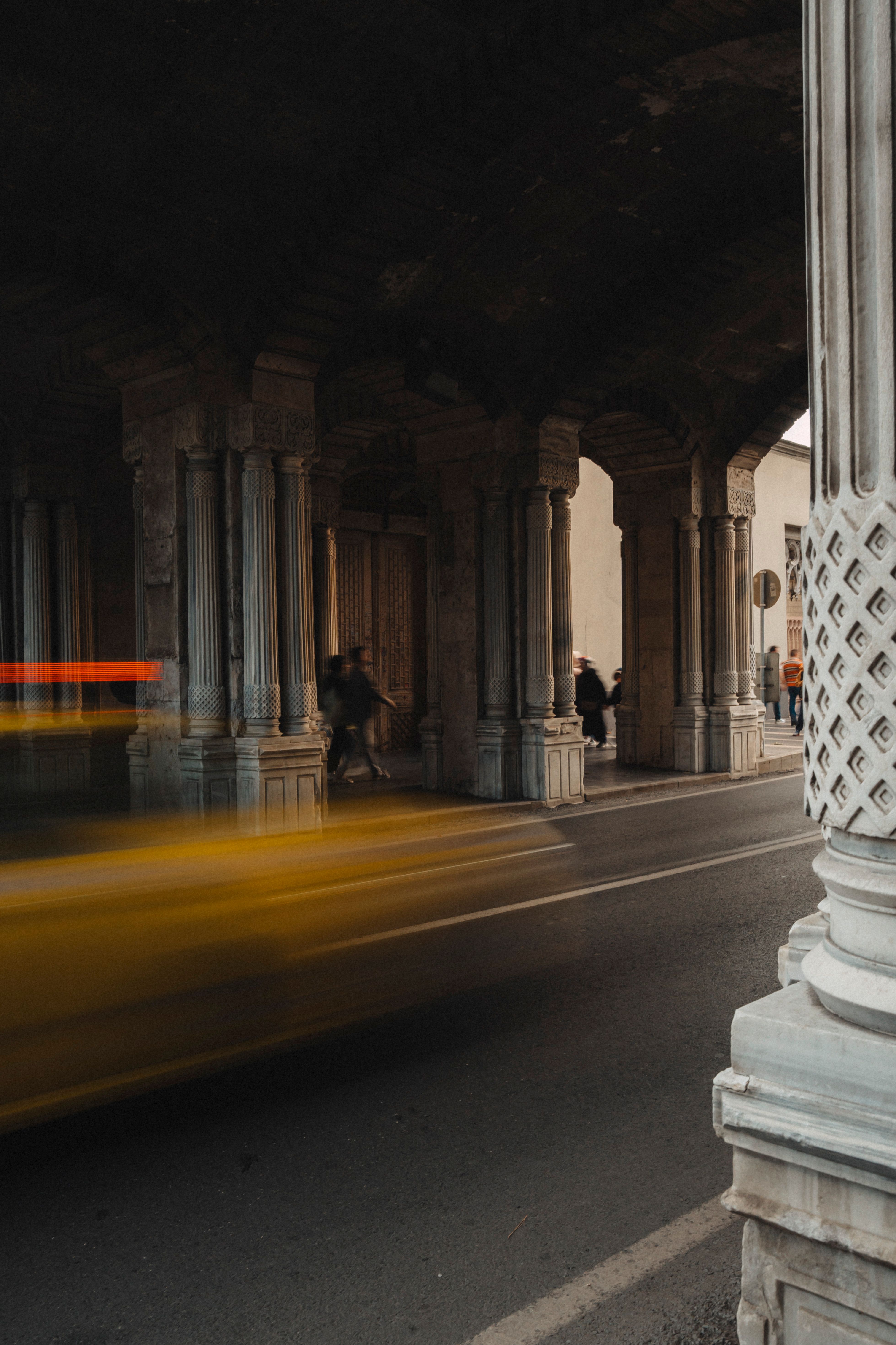 Blurred Yellow Taxi Passing Under Architectural Arches · Free Stock Photo