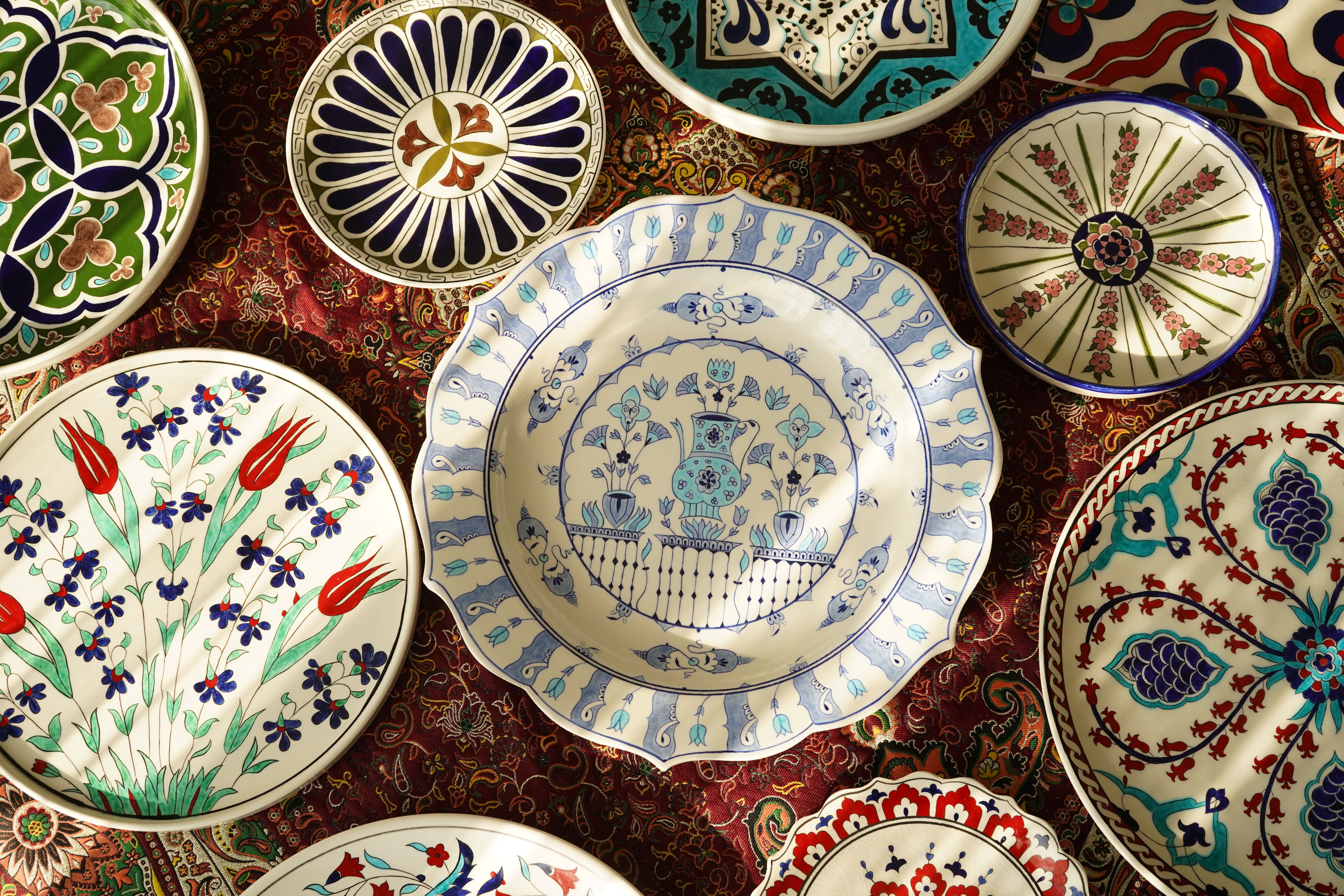 Colorful Traditional Ceramic Plates on Textile · Free Stock Photo