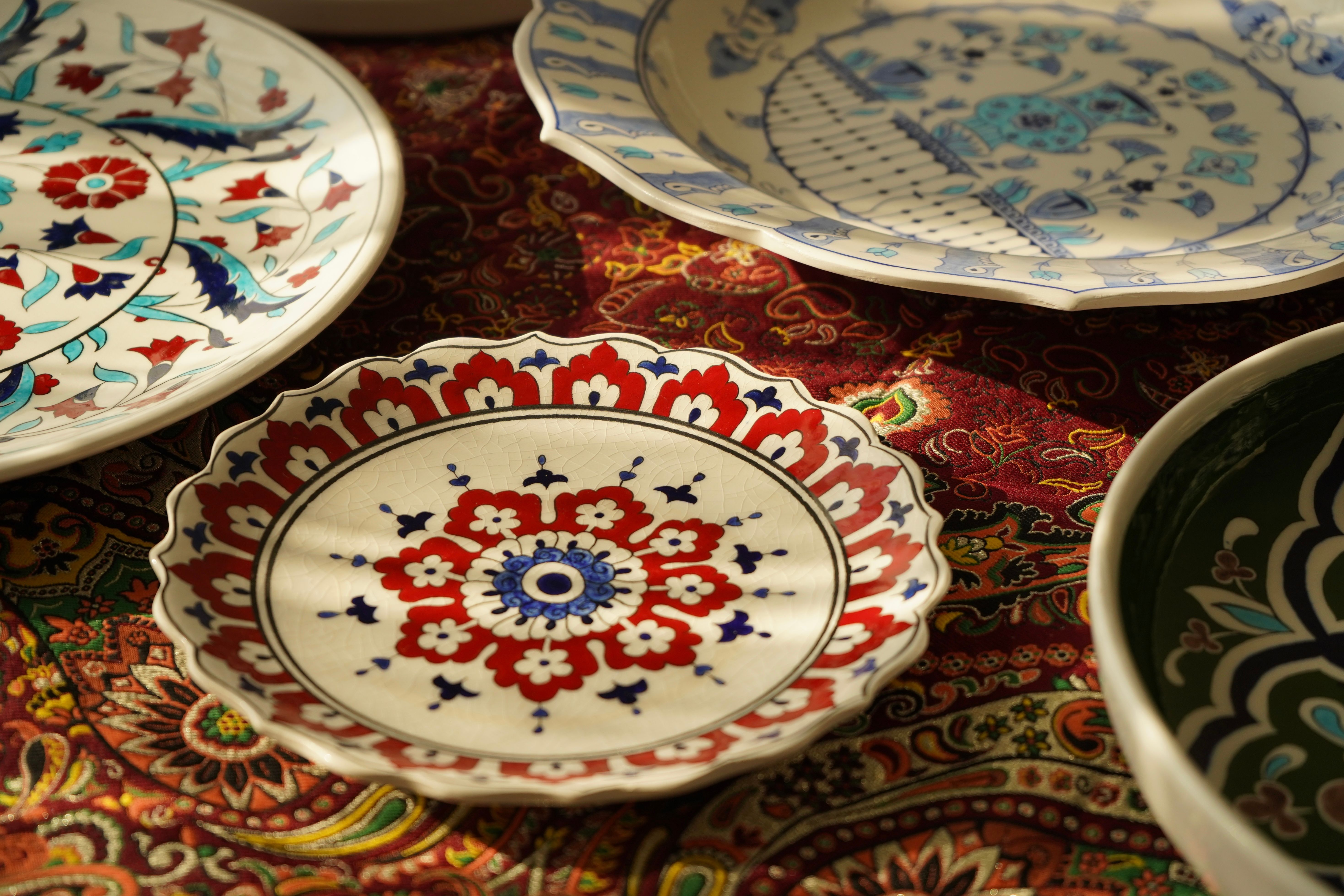 Colorful Ceramic Plates on Patterned Fabric · Free Stock Photo