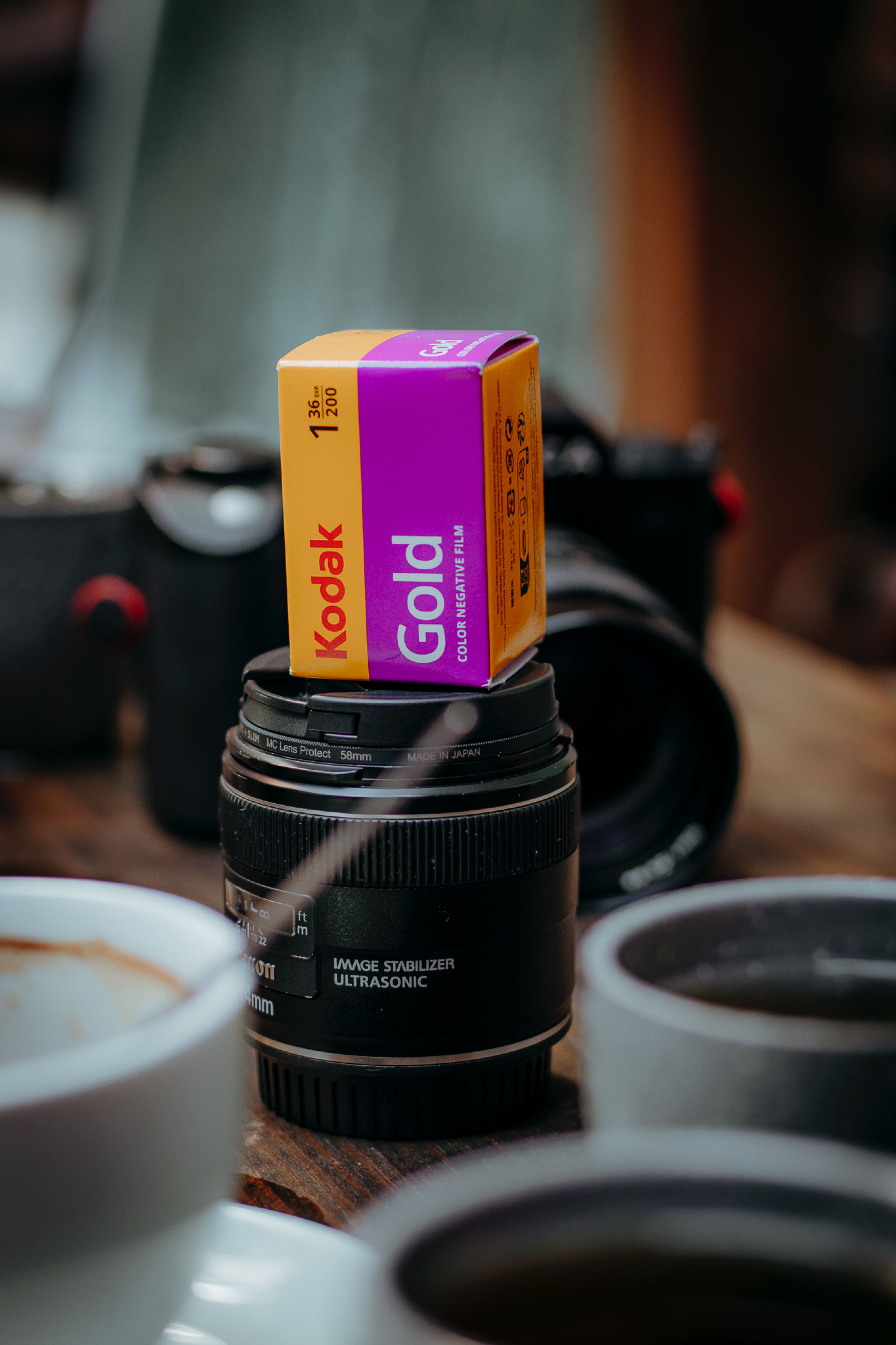 Kodak Film on Camera Lens in Cafe Setting · Free Stock Photo