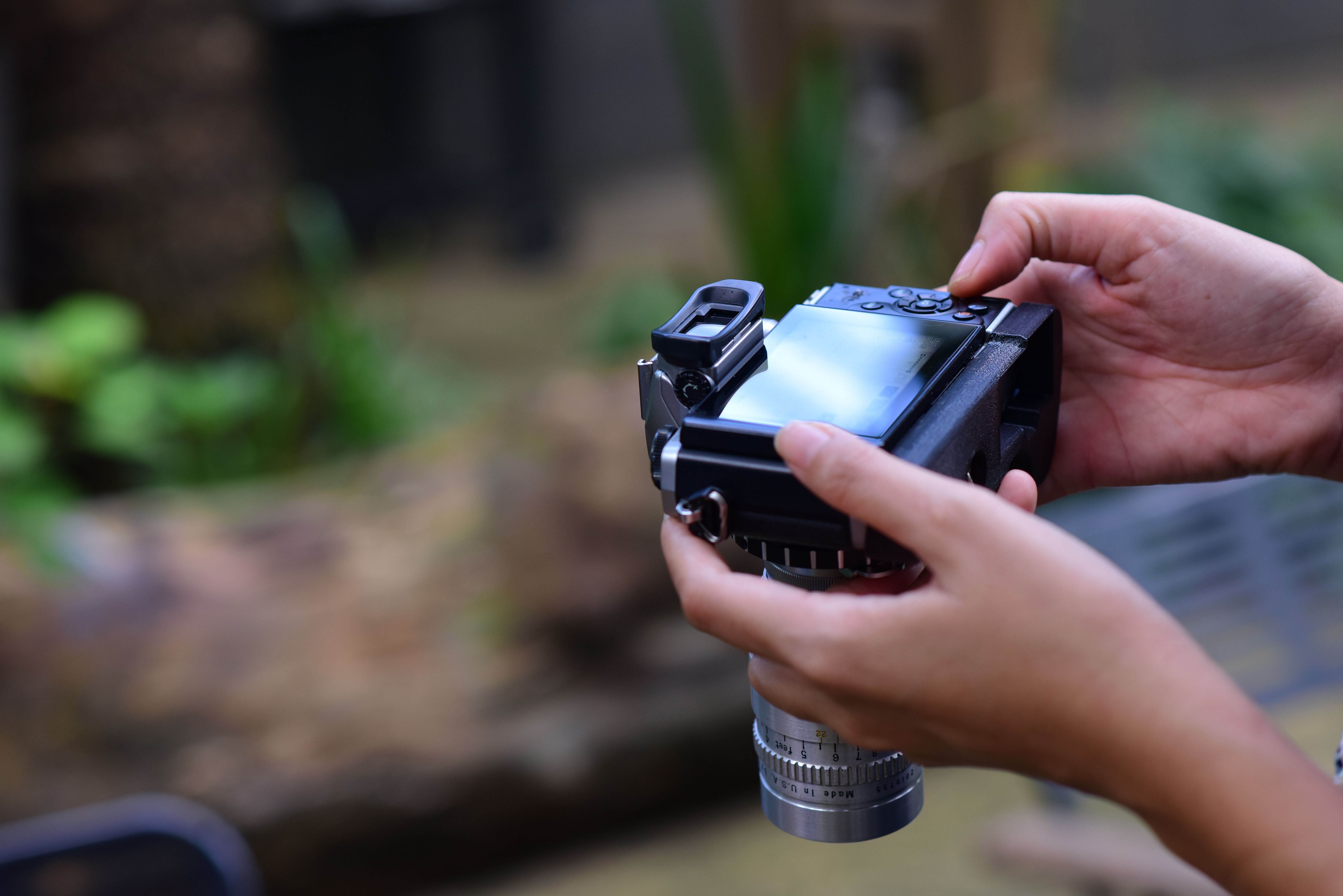 Close-up of photographer adjusting camera outdoors · Free Stock Photo