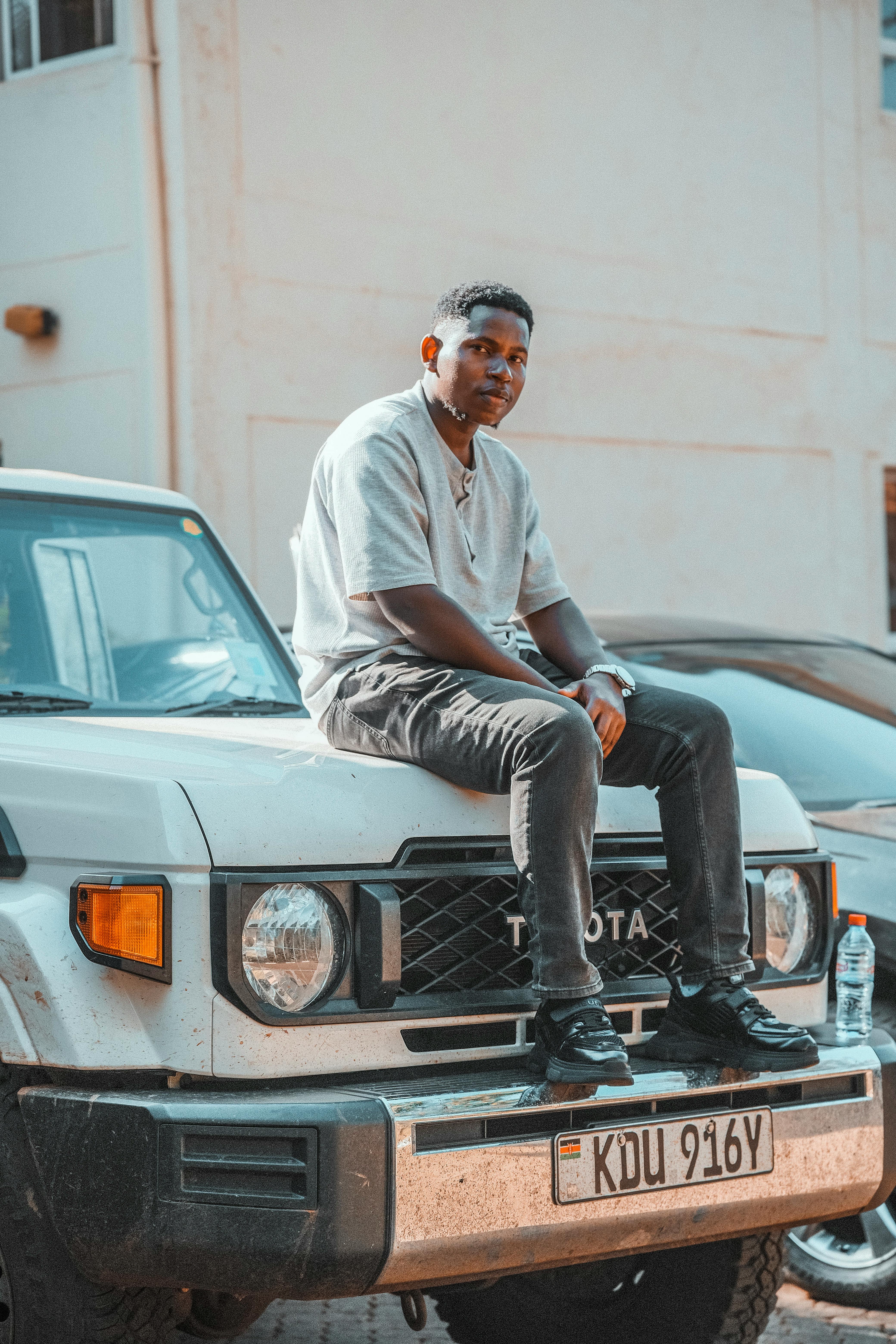 Young Man Sitting on SUV in Nairobi Kenya · Free Stock Photo