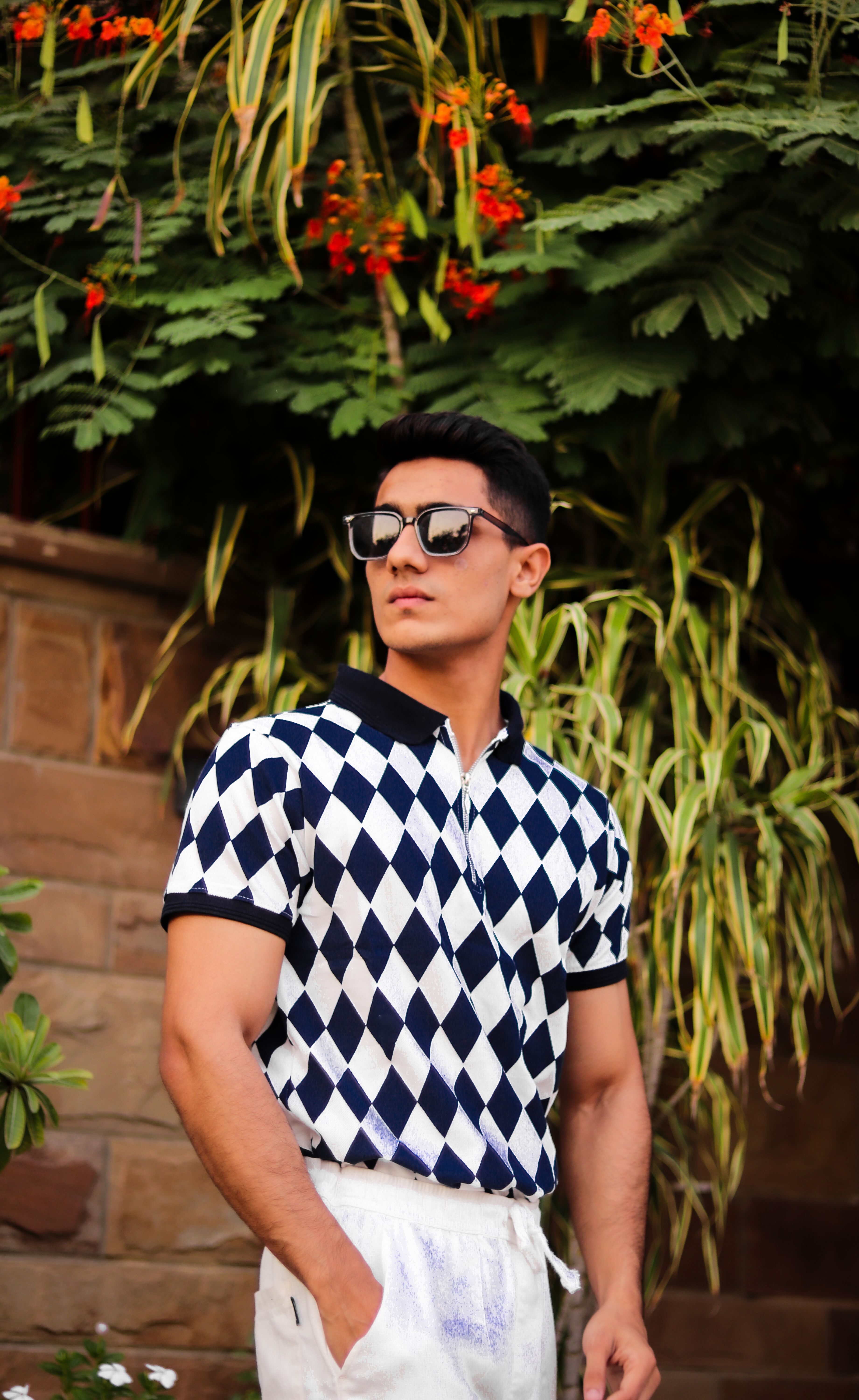 Stylish Man in Sunglasses with Vibrant Floral Background · Free Stock Photo