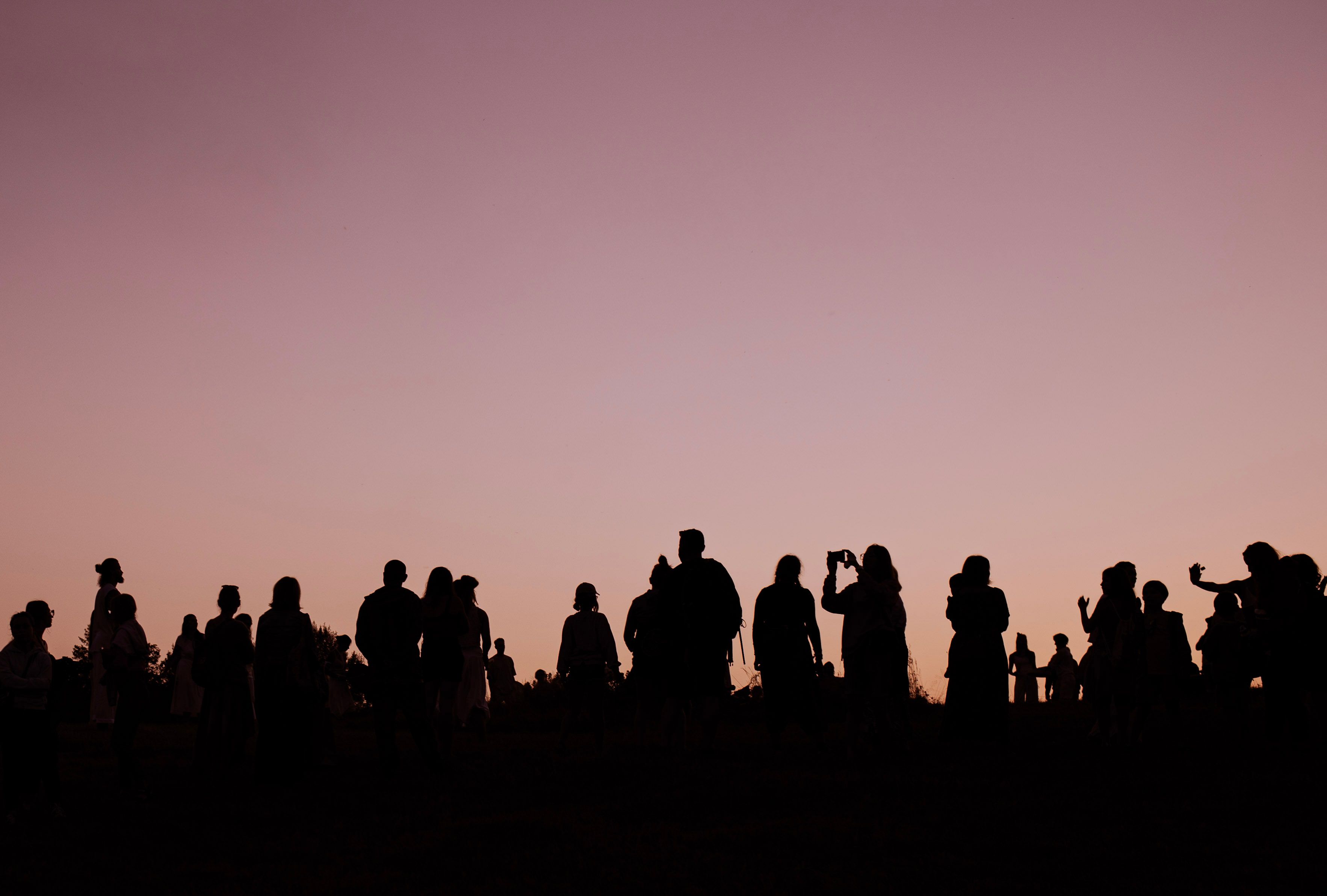 Silhouetted Crowd Against Vibrant Sunset Sky · Free Stock Photo