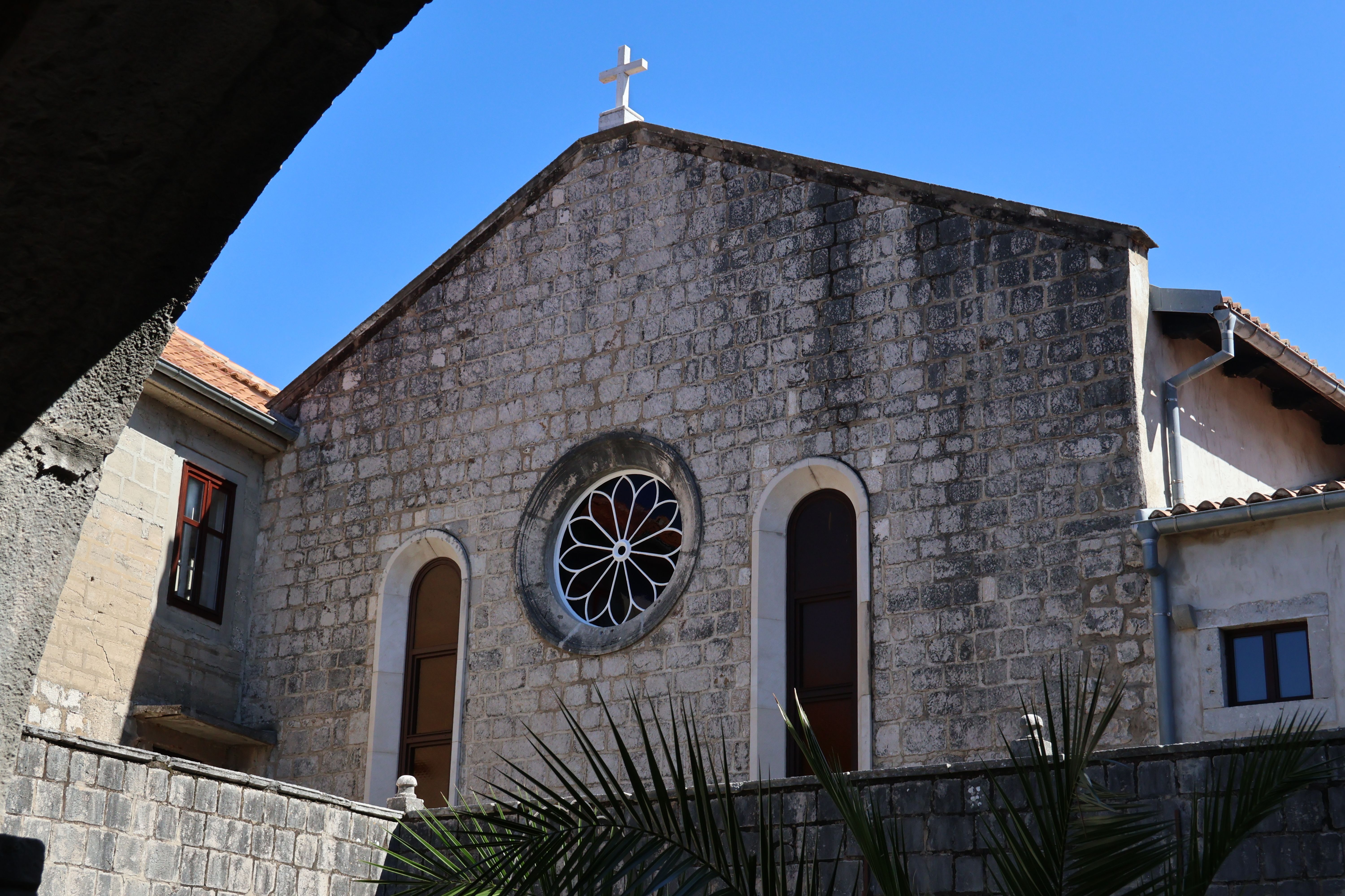 Historic Stone Church Facade Under Clear Blue Sky · Free Stock Photo