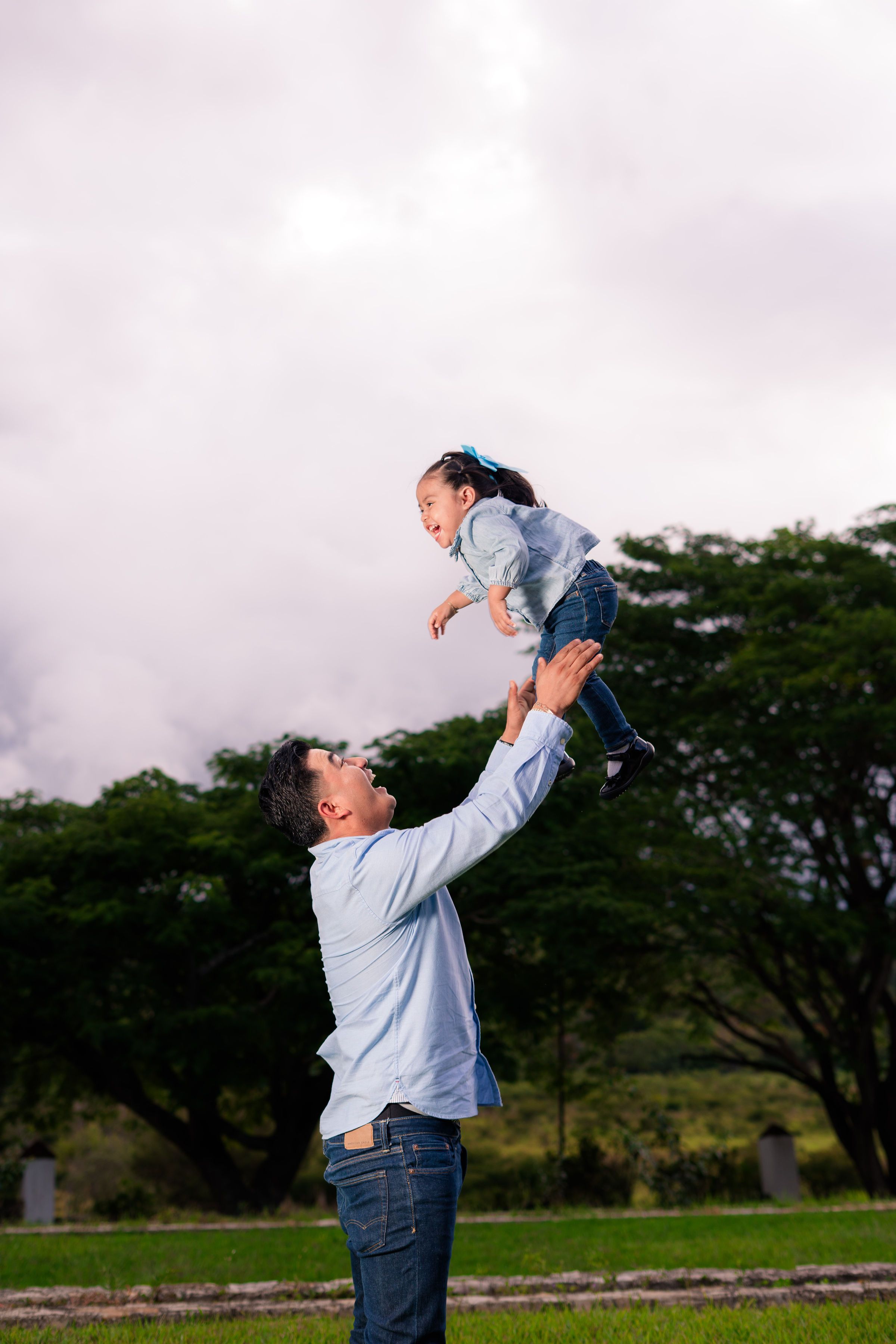 Father lifting daughter during outdoor playtime · Free Stock Photo