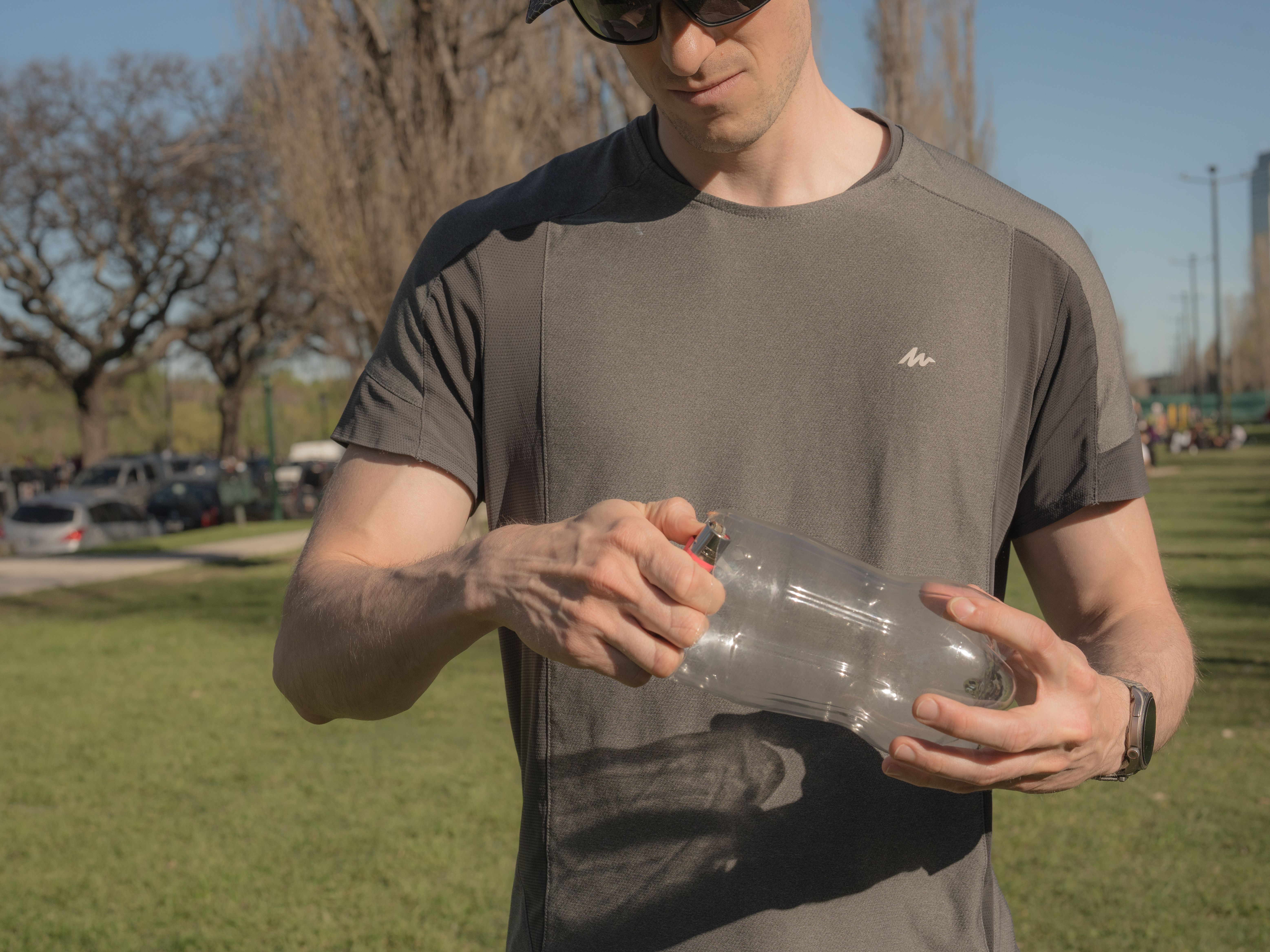Man Preparing Bottle Outdoors on Sunny Day · Free Stock Photo