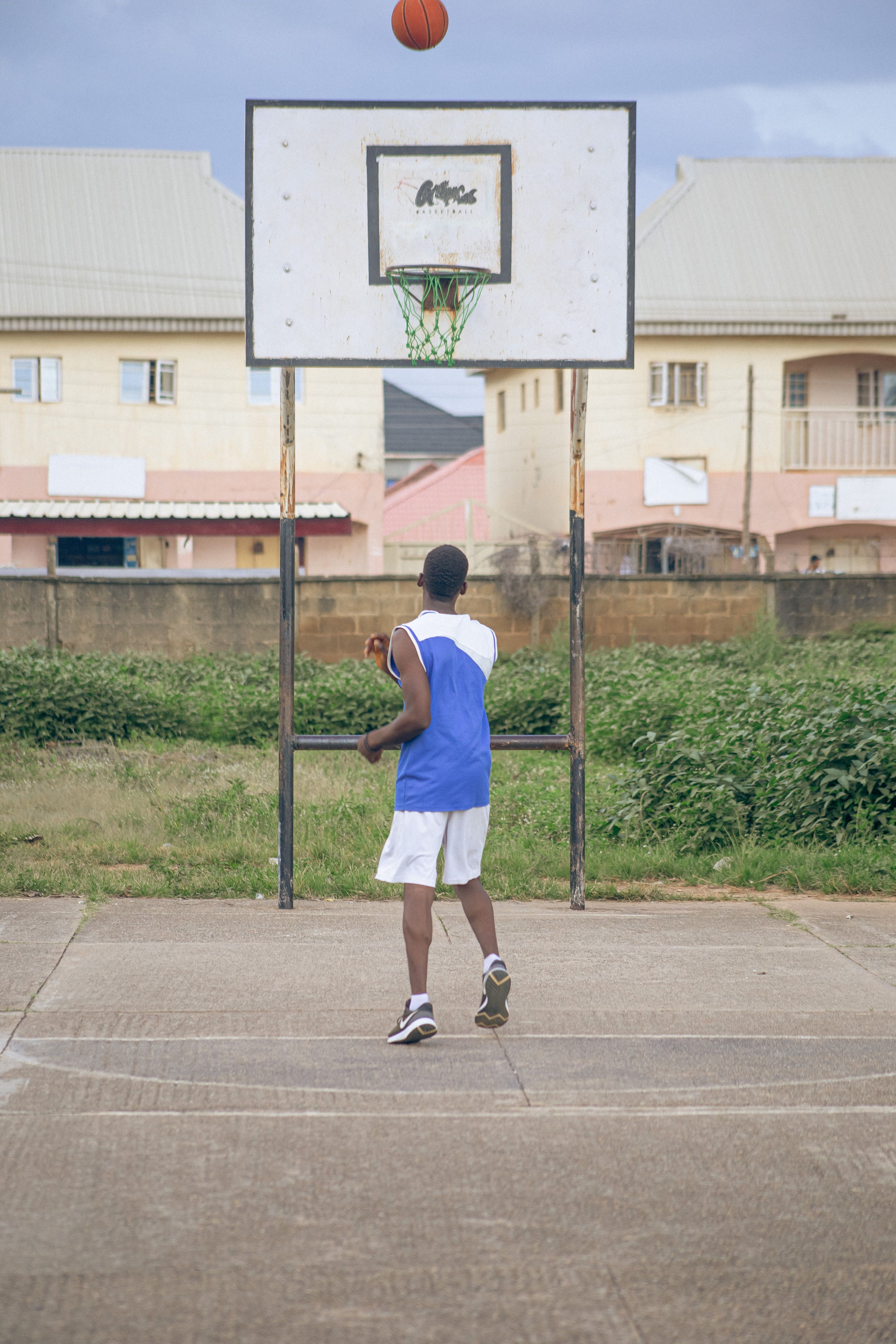 Young Athlete Shooting Hoops on Outdoor Court · Free Stock Photo