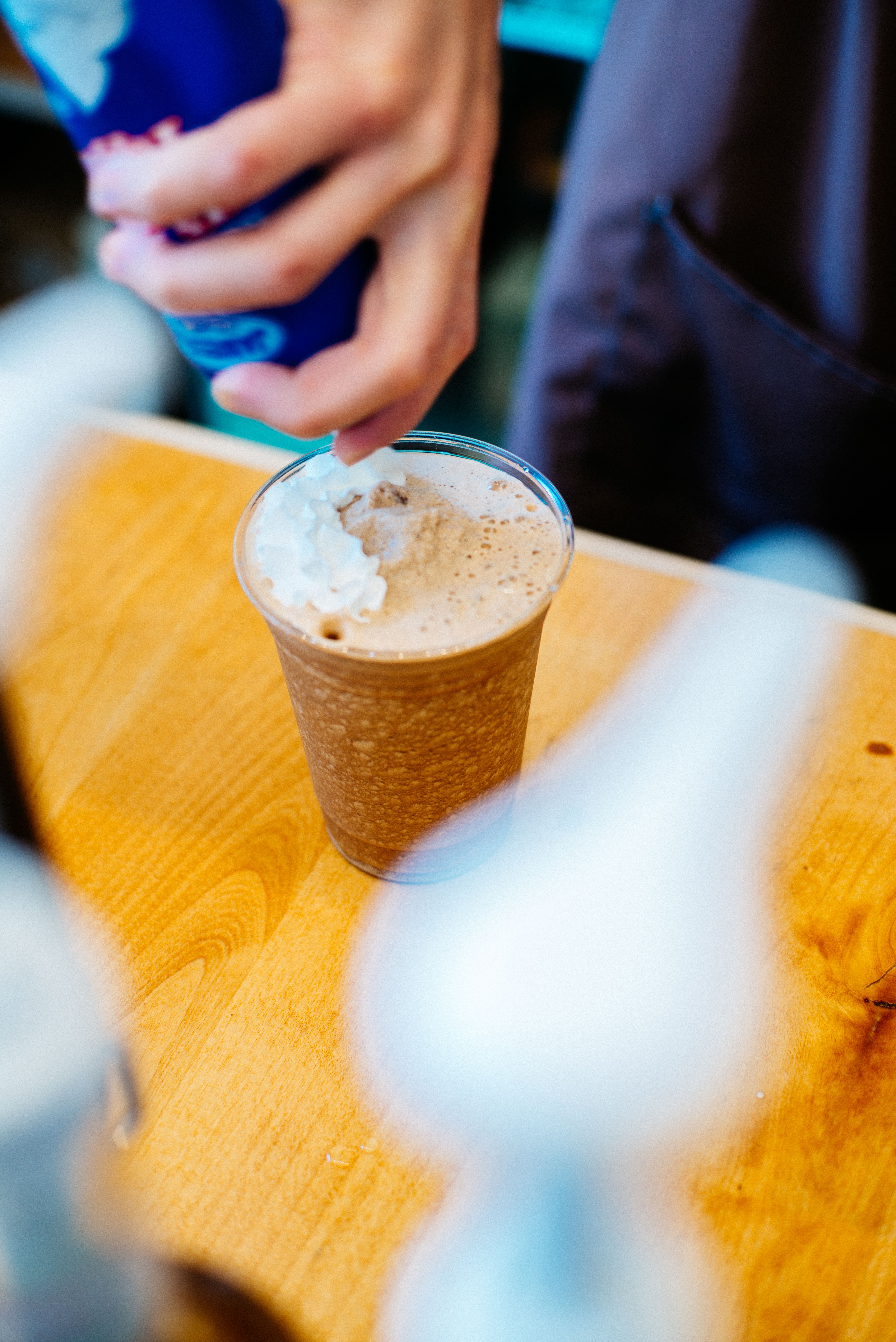 Barista Adding Whipped Cream to Iced Coffee · Free Stock Photo