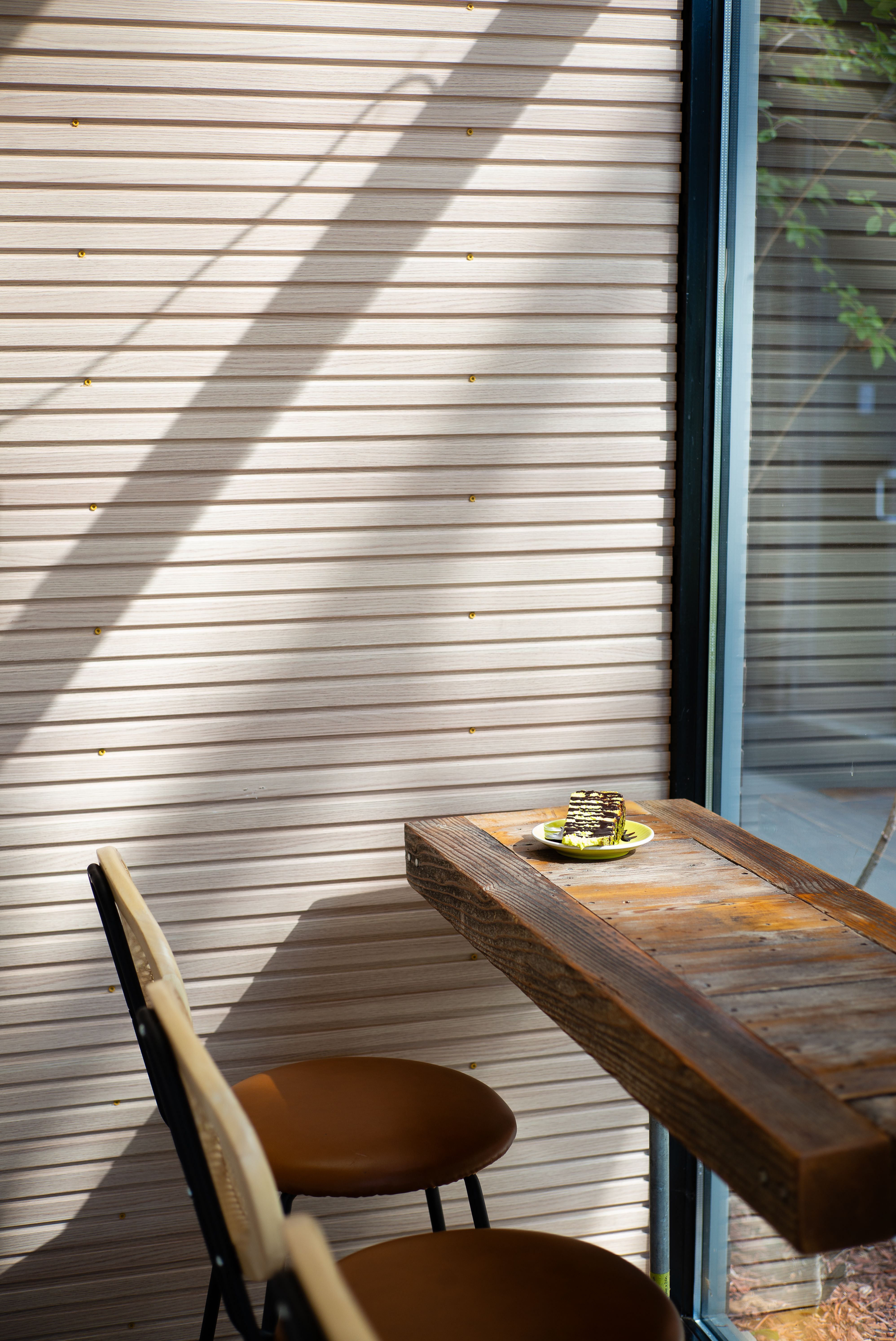 Cozy Coffee Shop Corner with Sunlit Table · Free Stock Photo