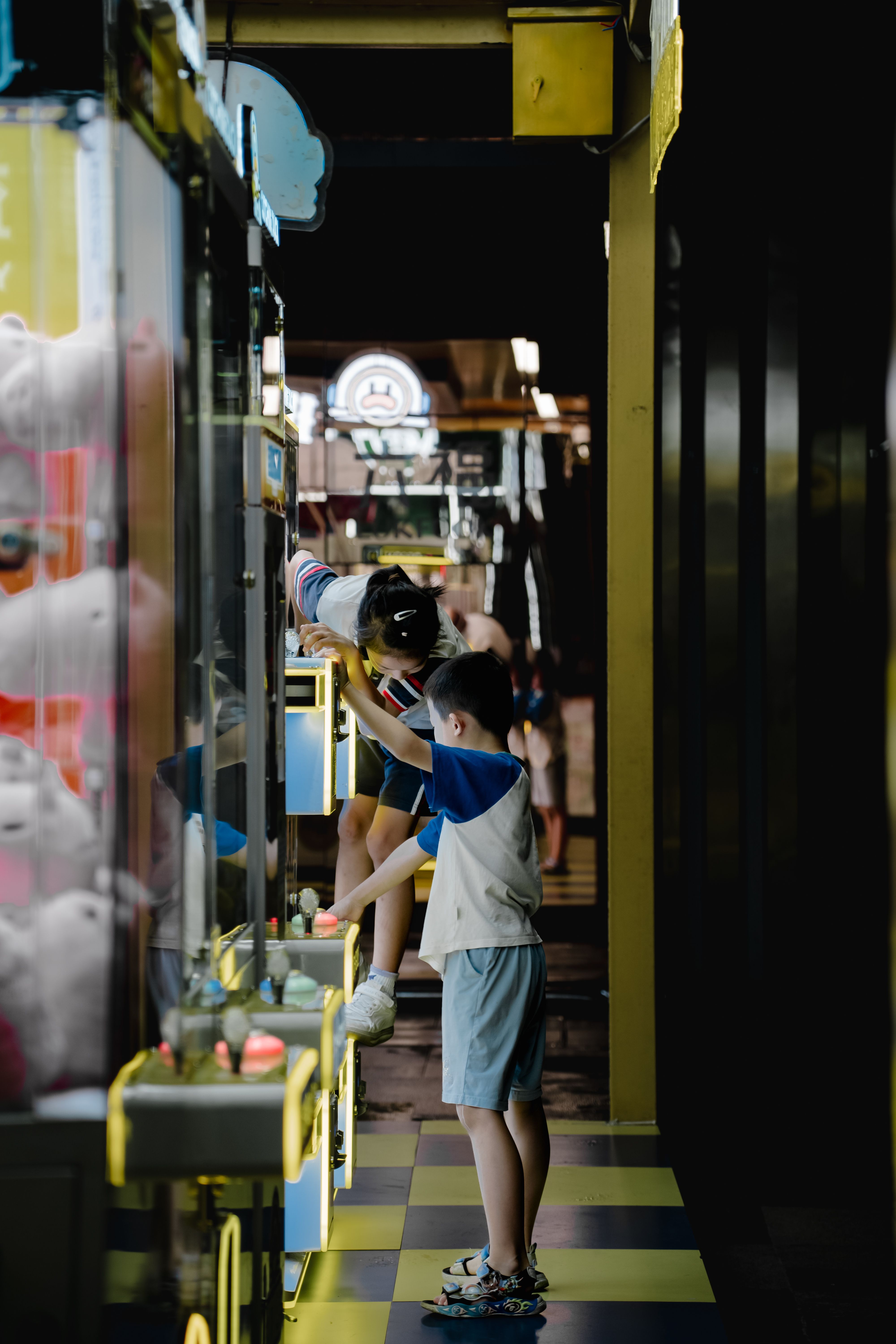 Children Playing with Vending Machine Indoors · Free Stock Photo