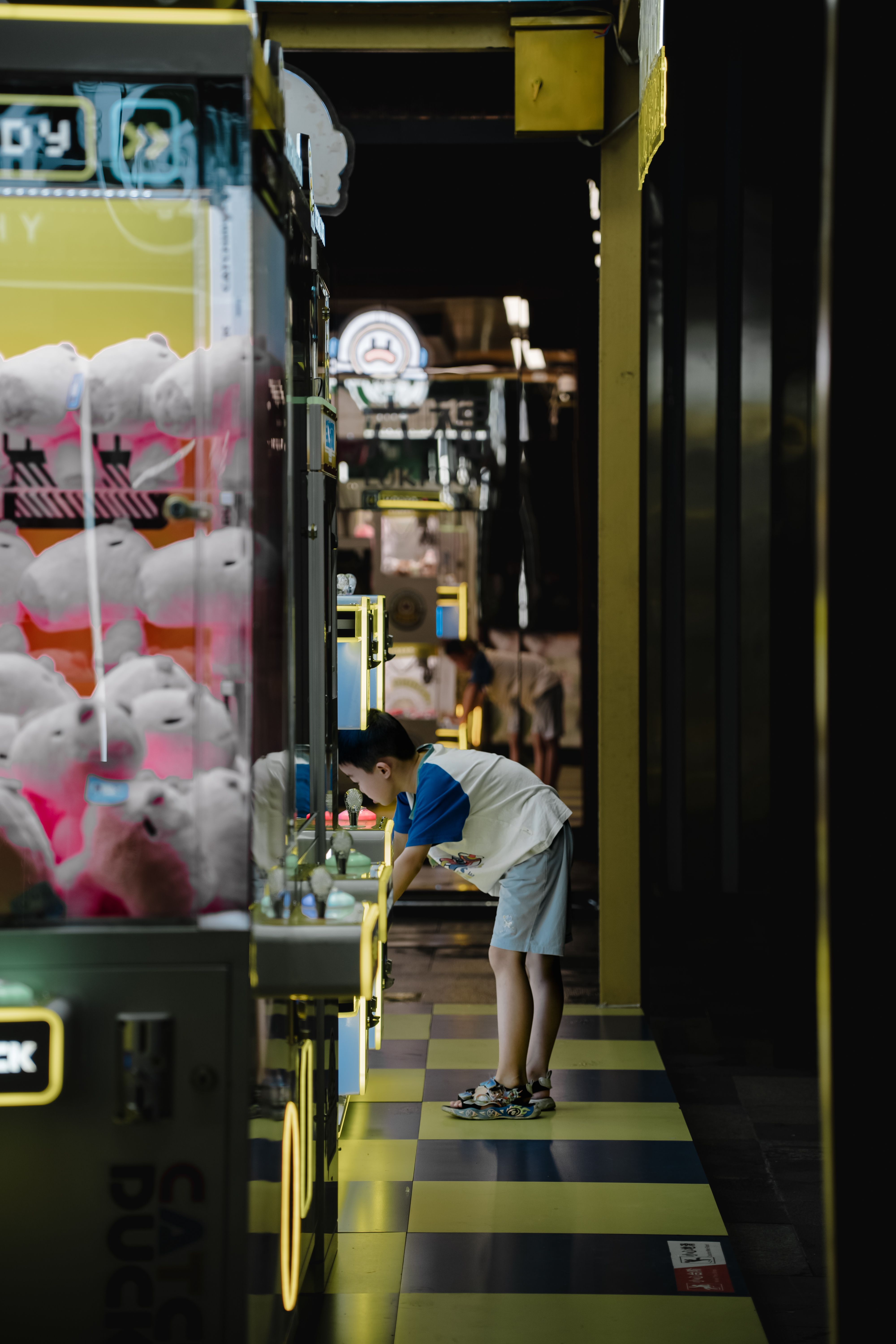 Child Playing at Arcade Claw Machine · Free Stock Photo
