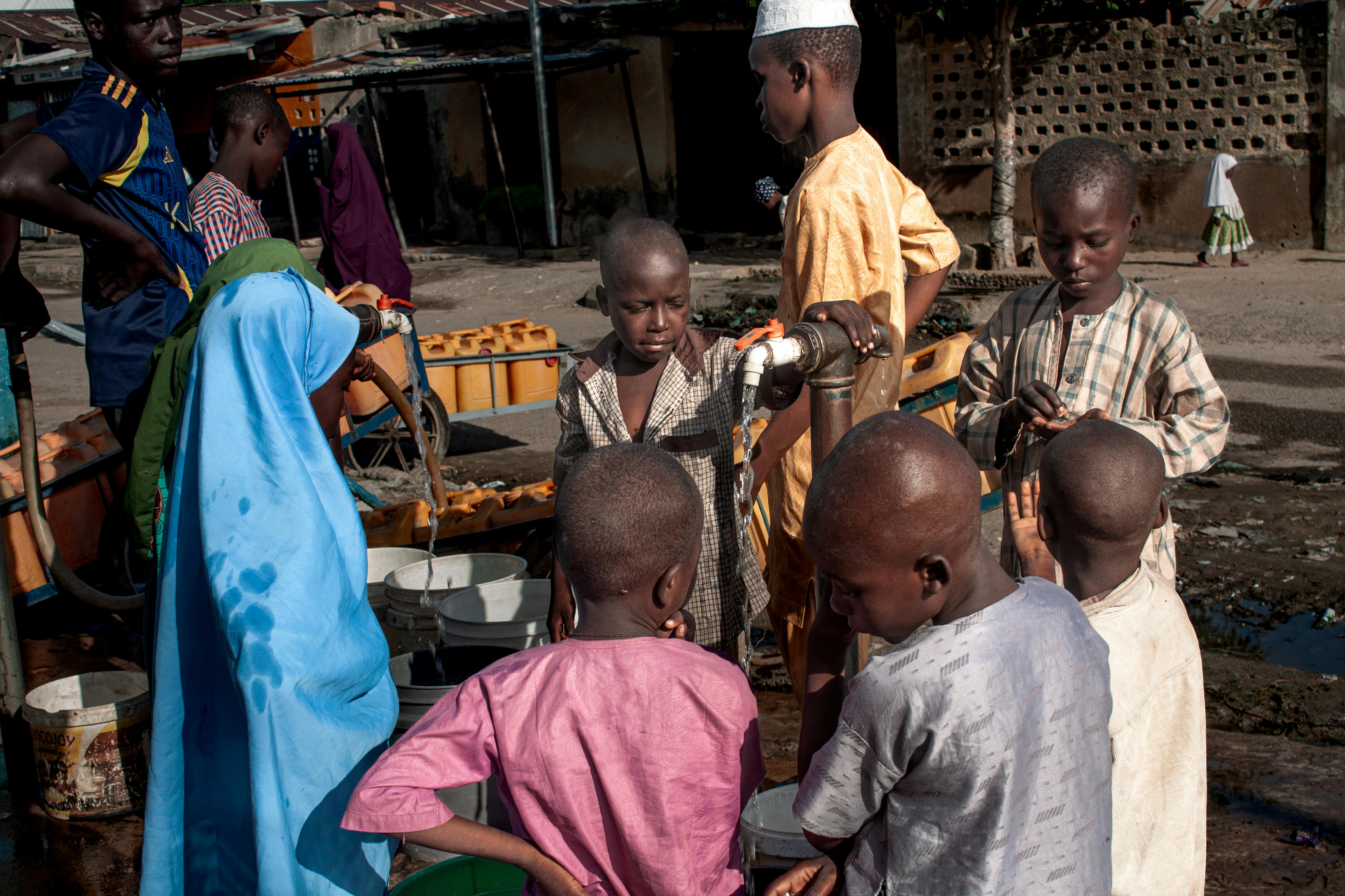 Children Gathering Water from a Communal Tap · Free Stock Photo