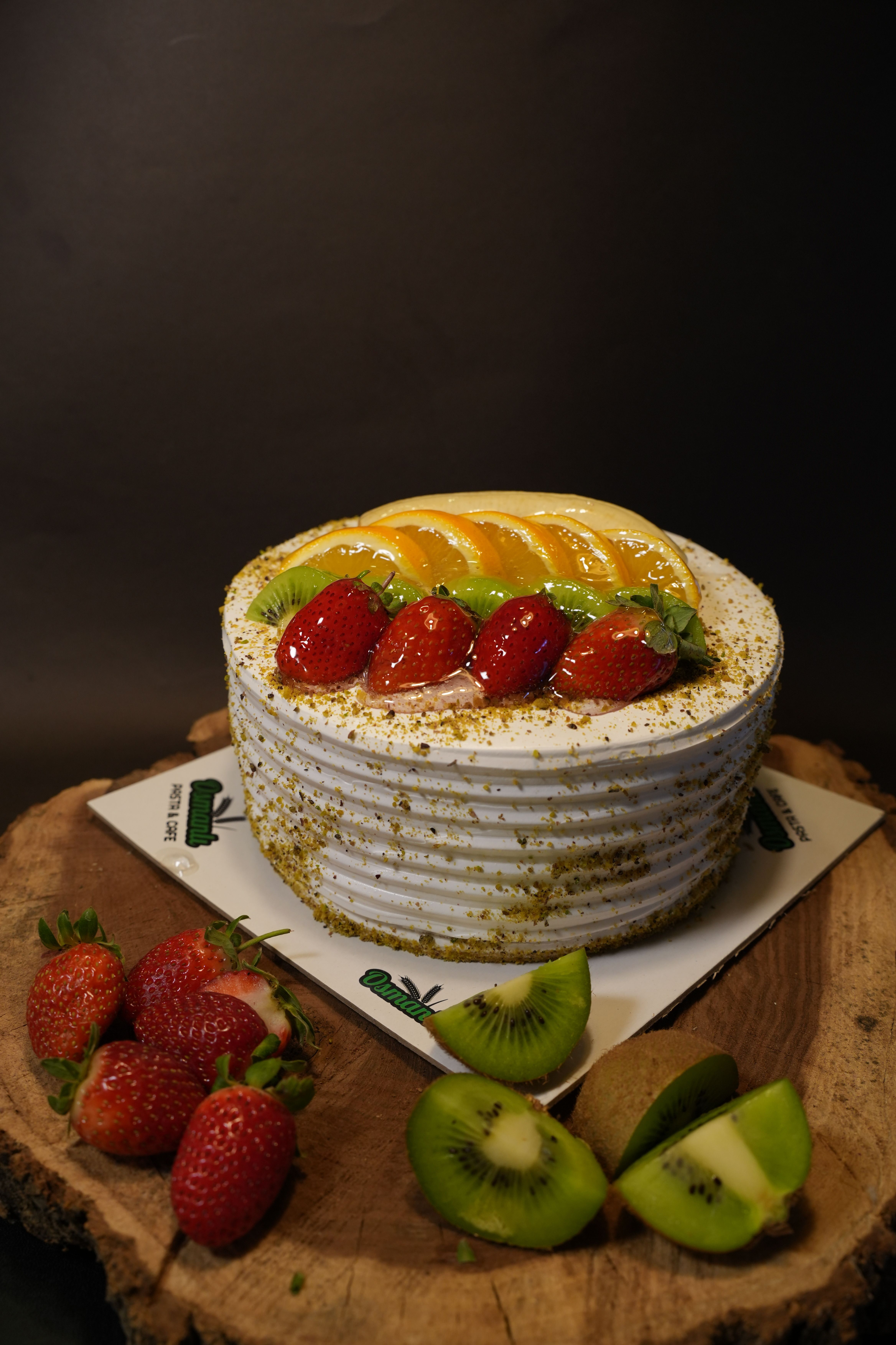 Delicious Fruit-Topped Celebration Cake on Rustic Table · Free Stock Photo