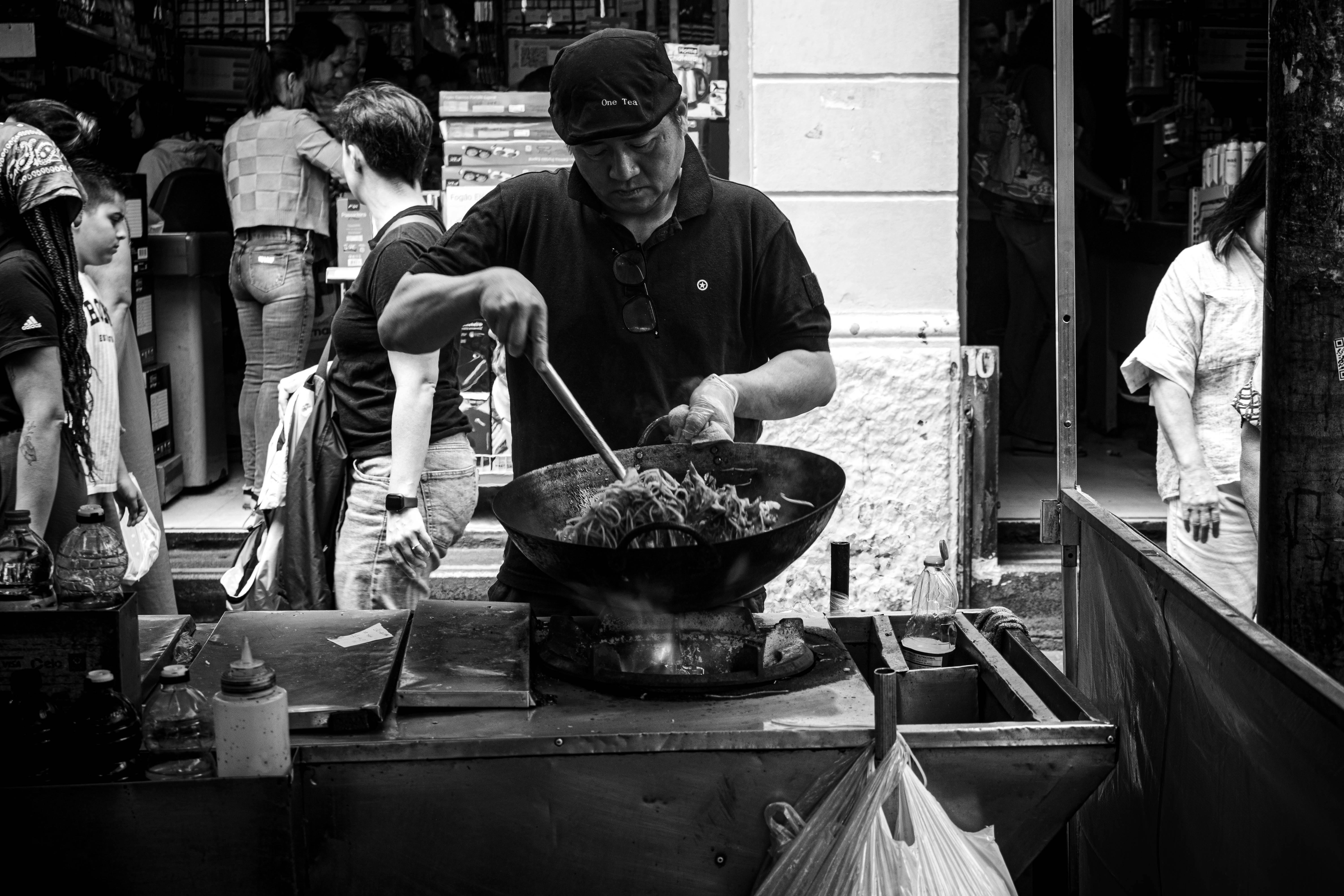 Street Food Vendor Cooking in Bustling Market · Free Stock Photo