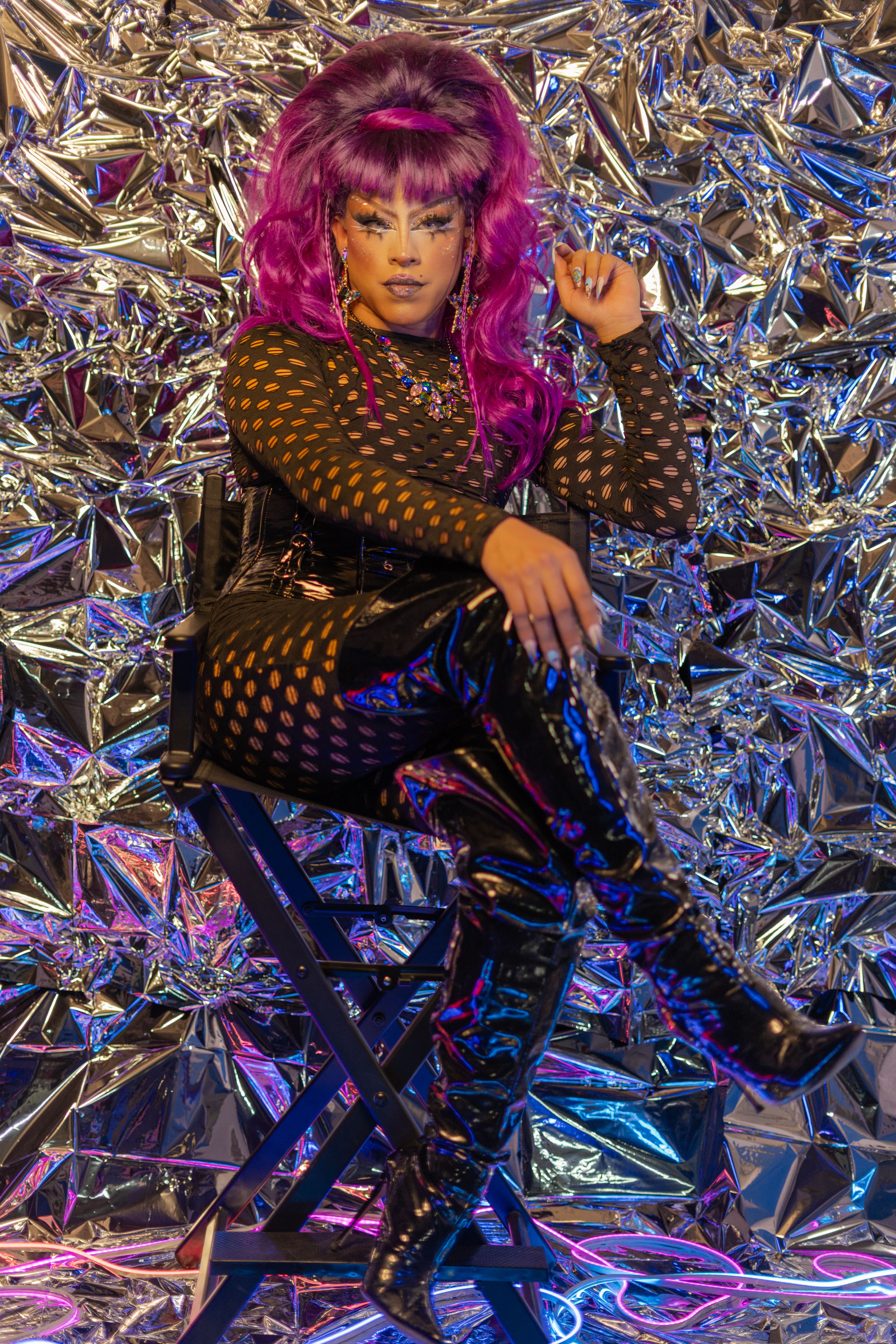Vibrant Drag Queen Sitting on Director's Chair · Free Stock Photo
