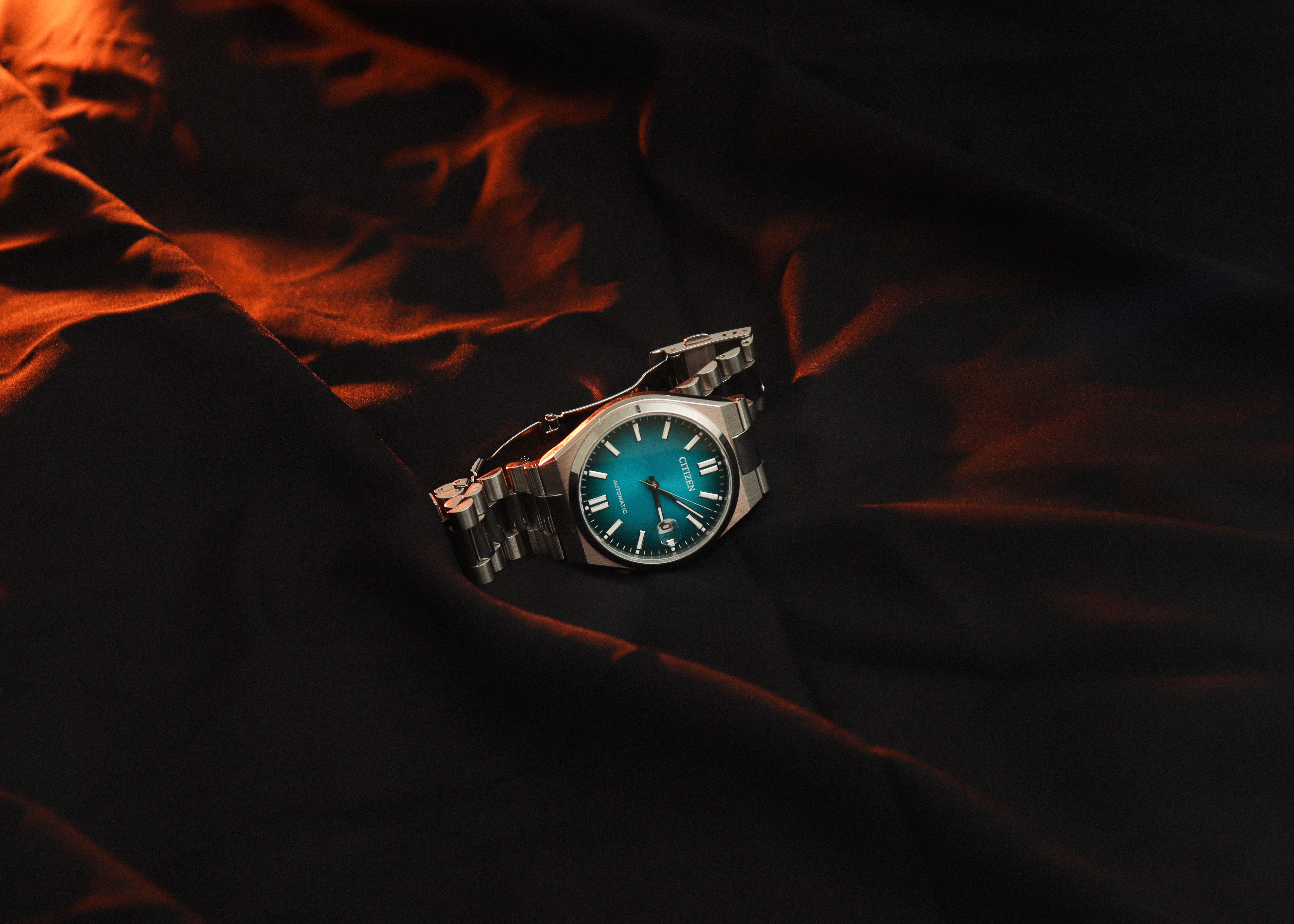 Luxury Silver Watch with Teal Dial on Dark Fabric · Free Stock Photo
