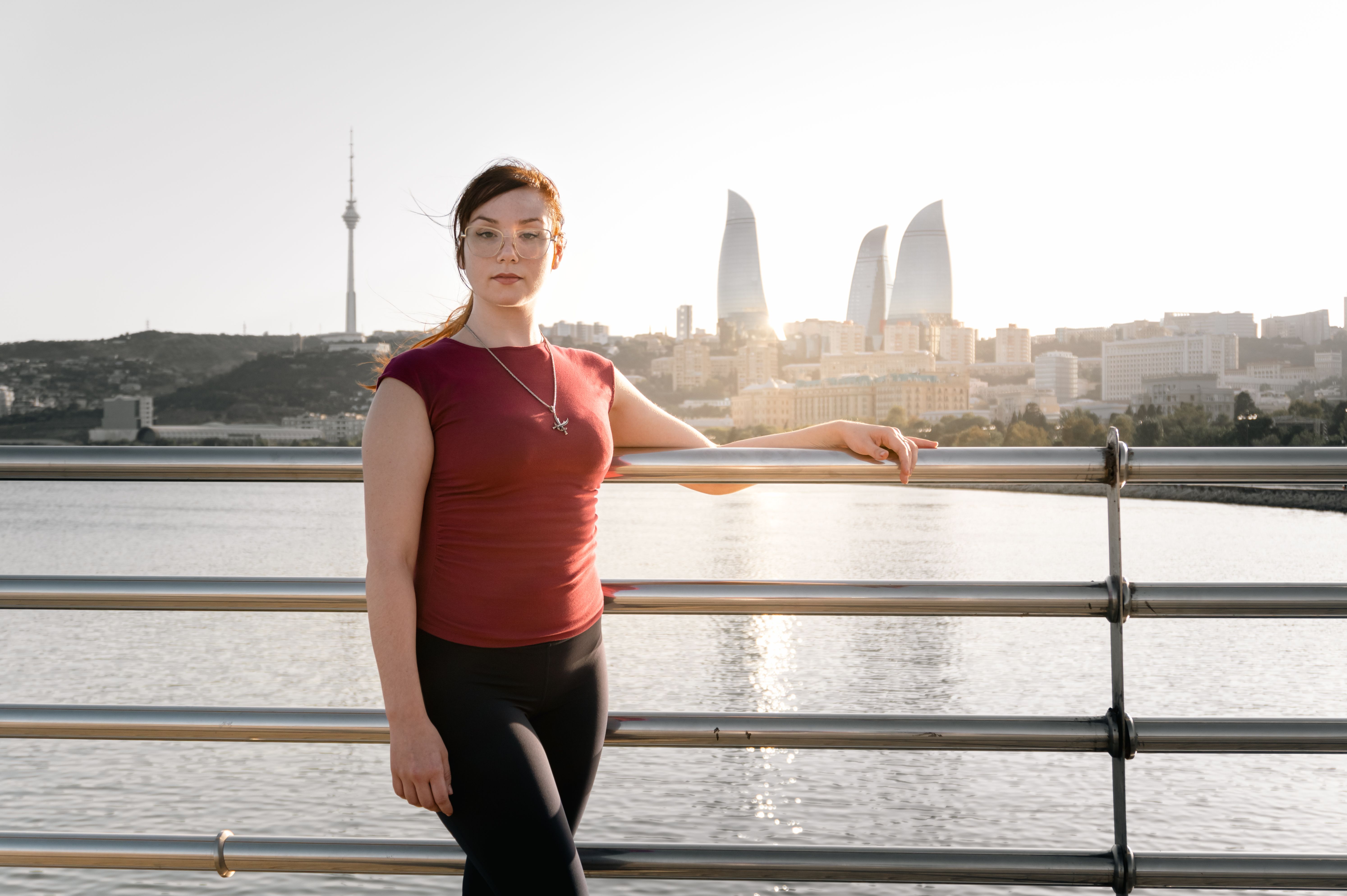 Young Woman Posing in Baku with Flame Towers · Free Stock Photo