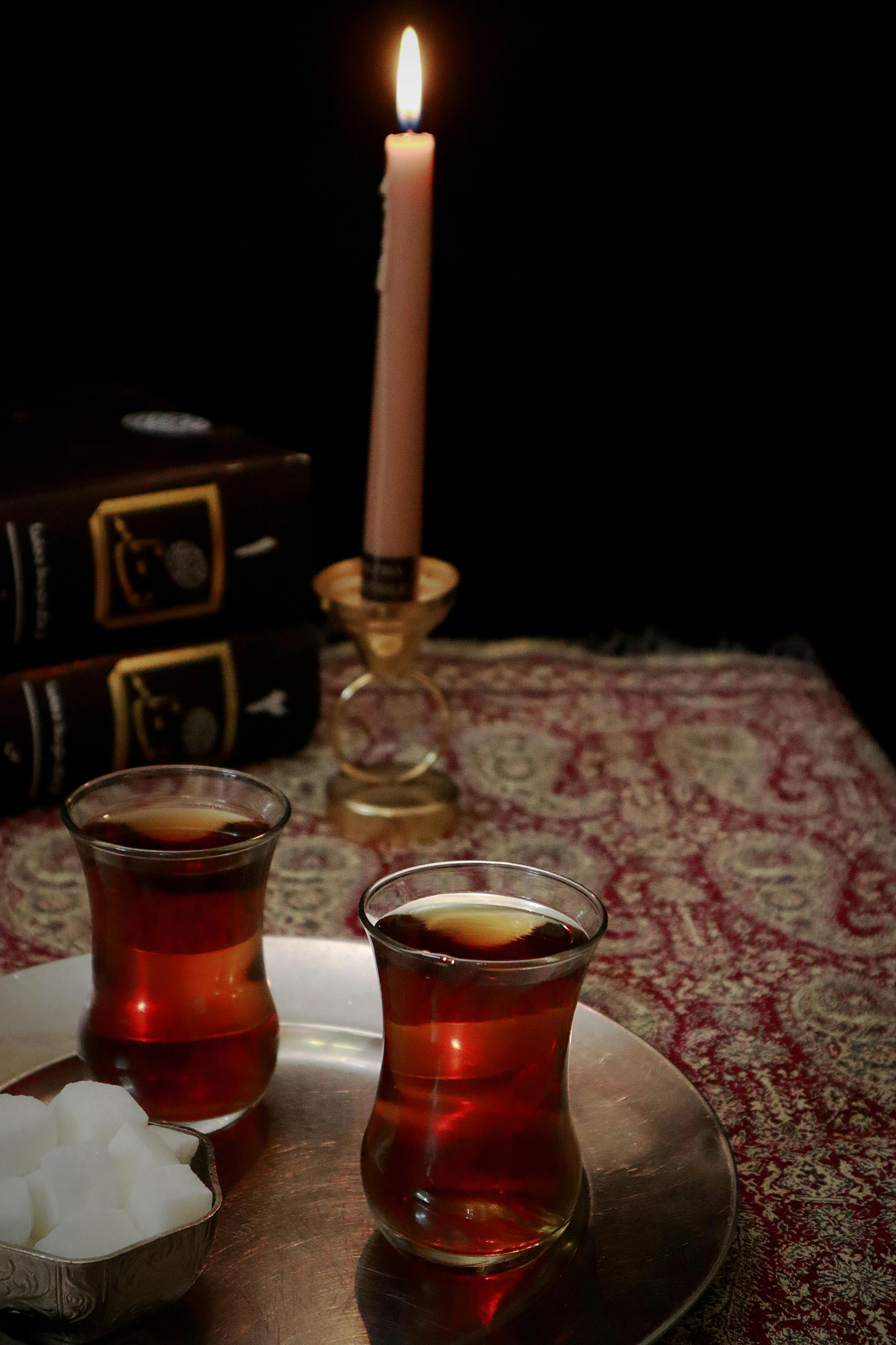 Cozy Candlelit Persian Tea Setting with Books · Free Stock Photo