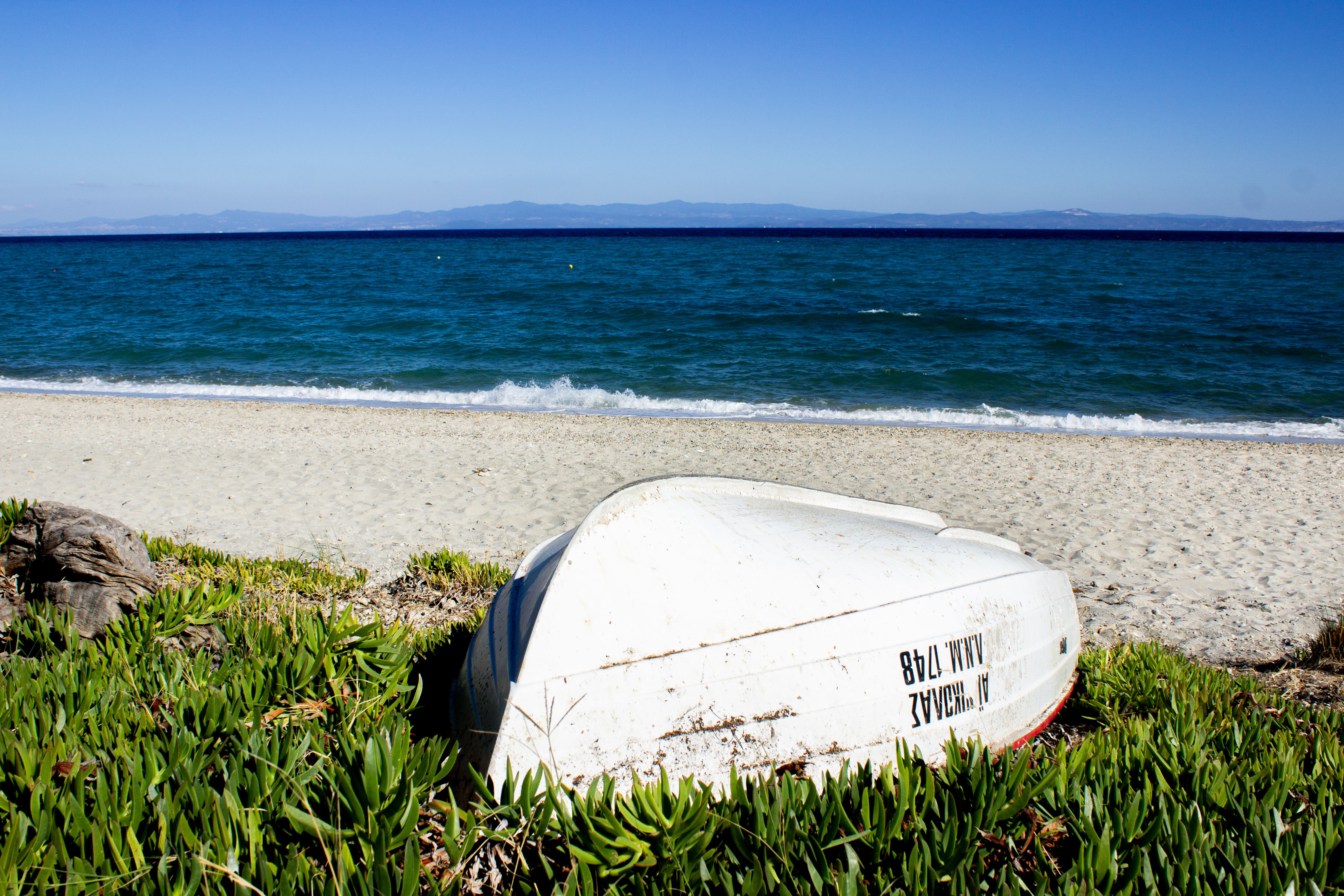 Beached Boat on Tranquil Greek Shoreline · Free Stock Photo