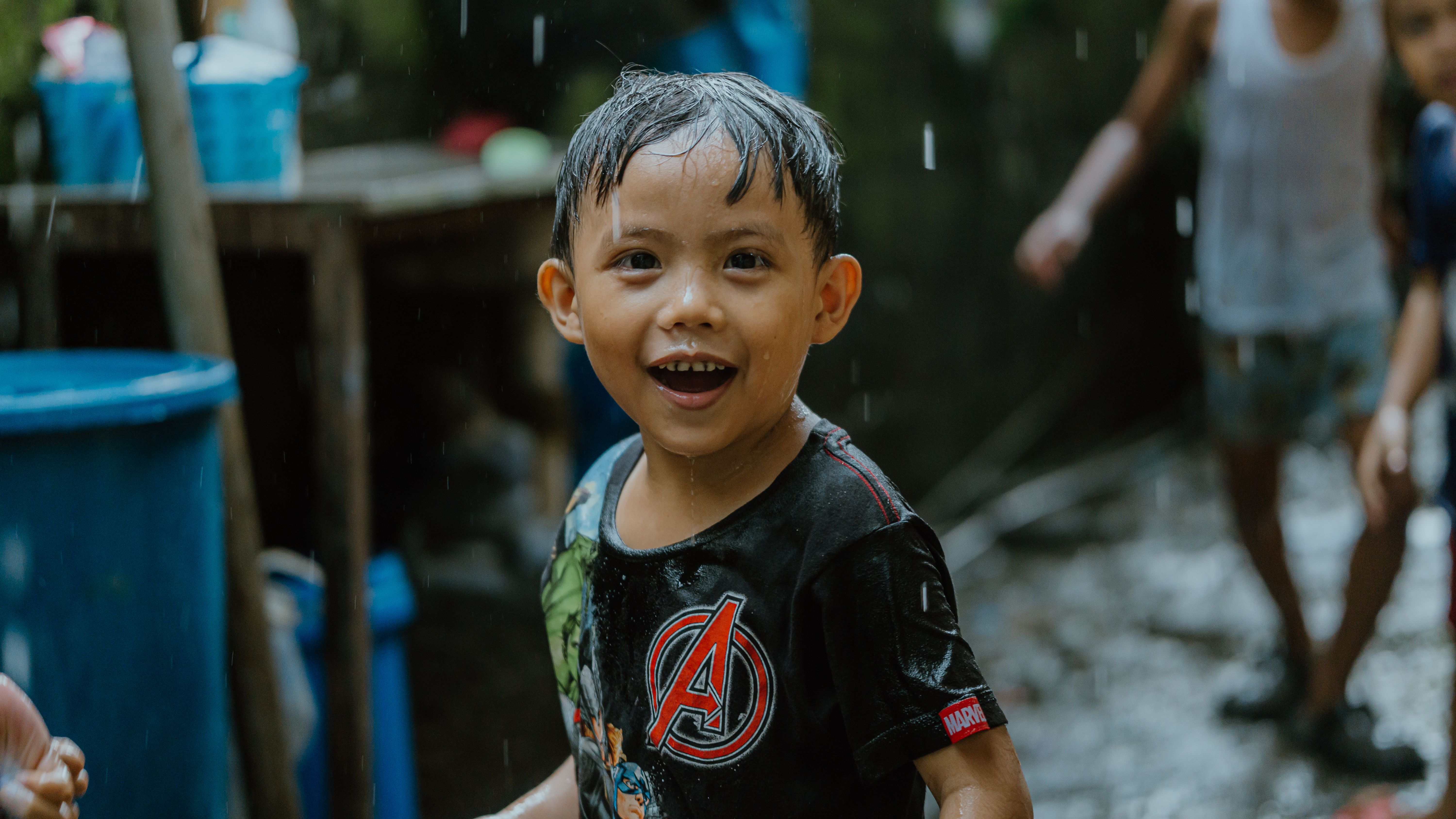 Joyful Child Playing in the Rain Outdoors · Free Stock Photo