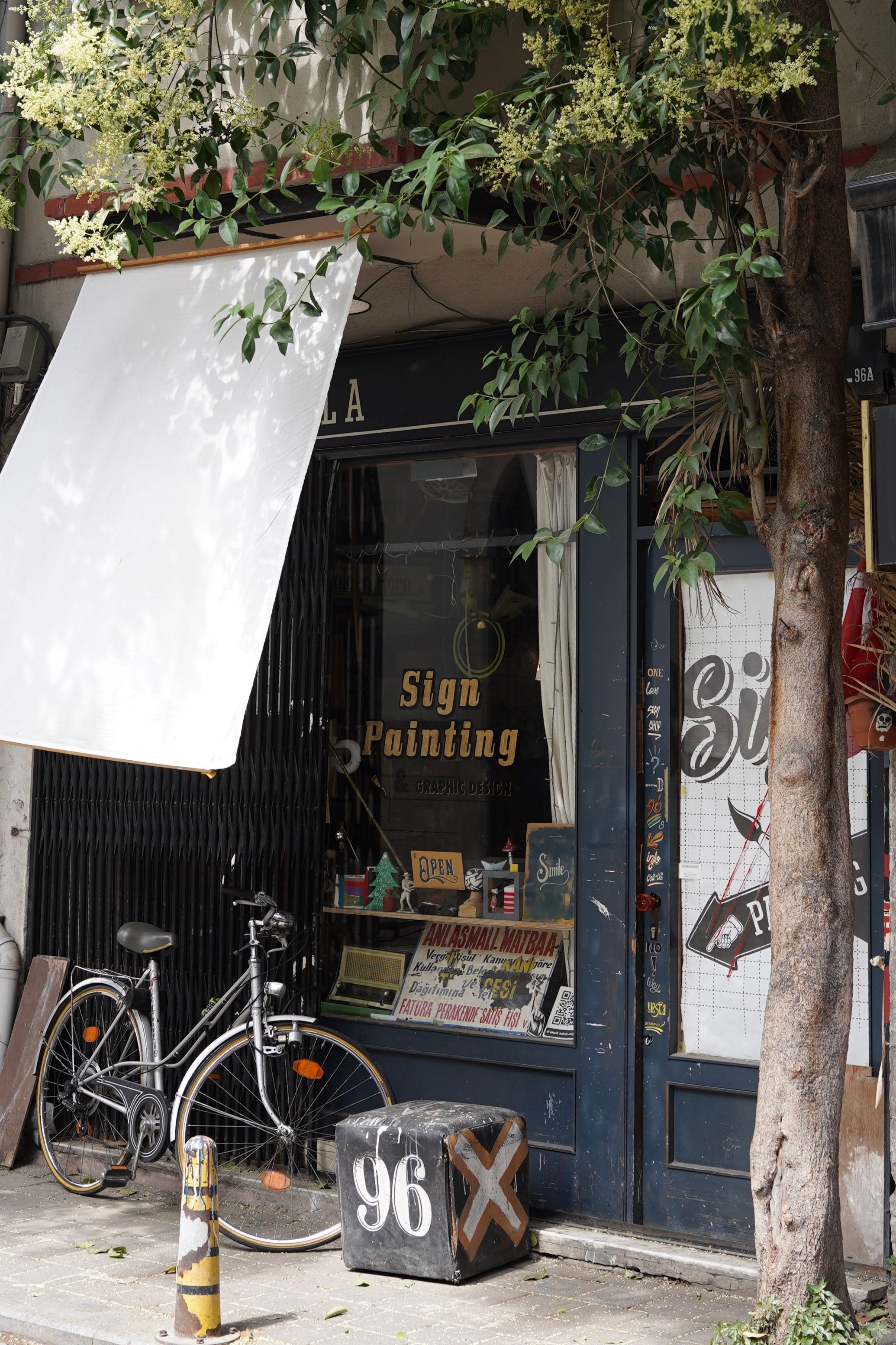 Vintage Sign Painting Shop with Bicycle Outdoors · Free Stock Photo