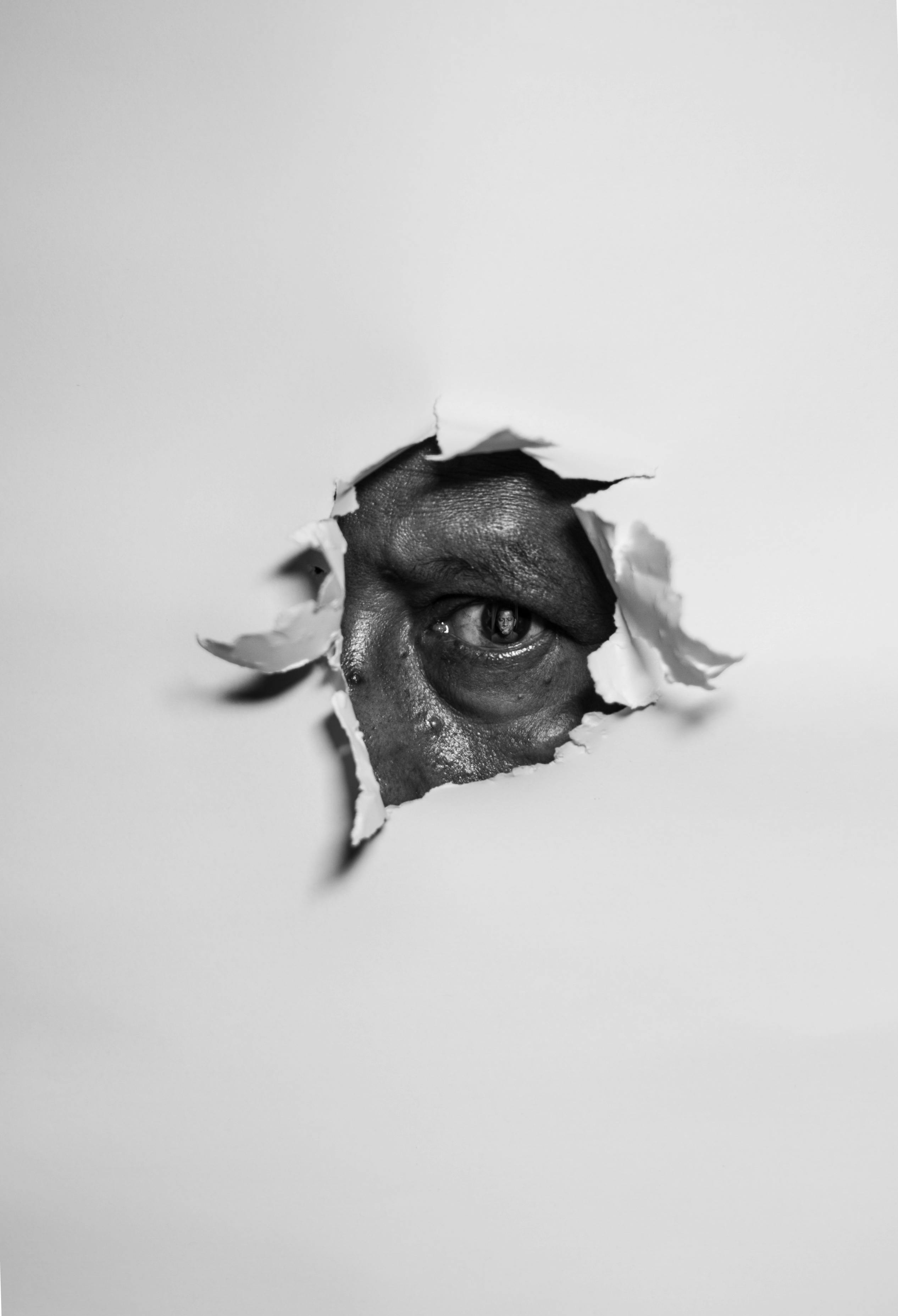 Human Eye Peeking Through Torn Paper · Free Stock Photo