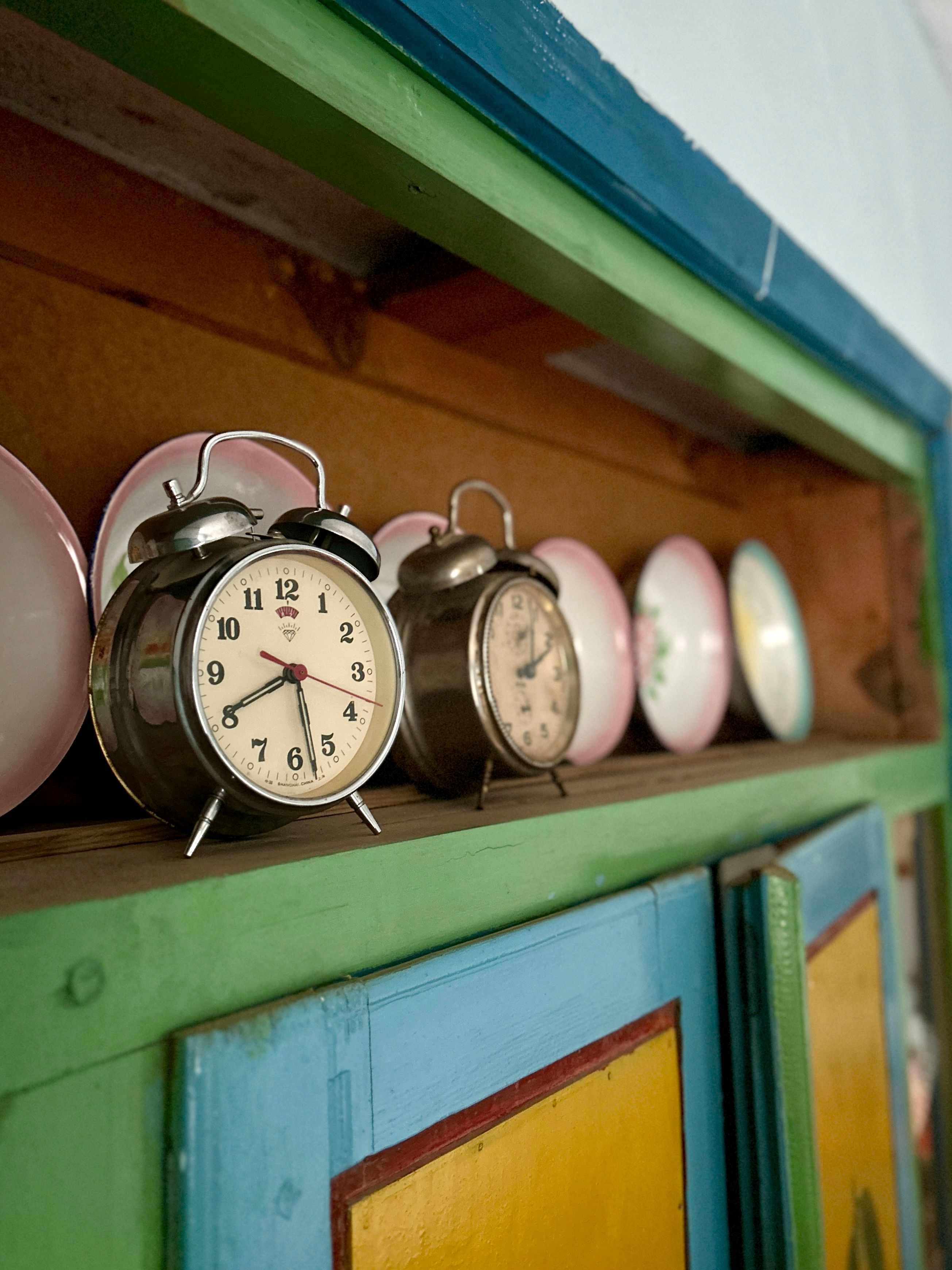 Vintage Alarm Clocks on Colorful Shelf · Free Stock Photo