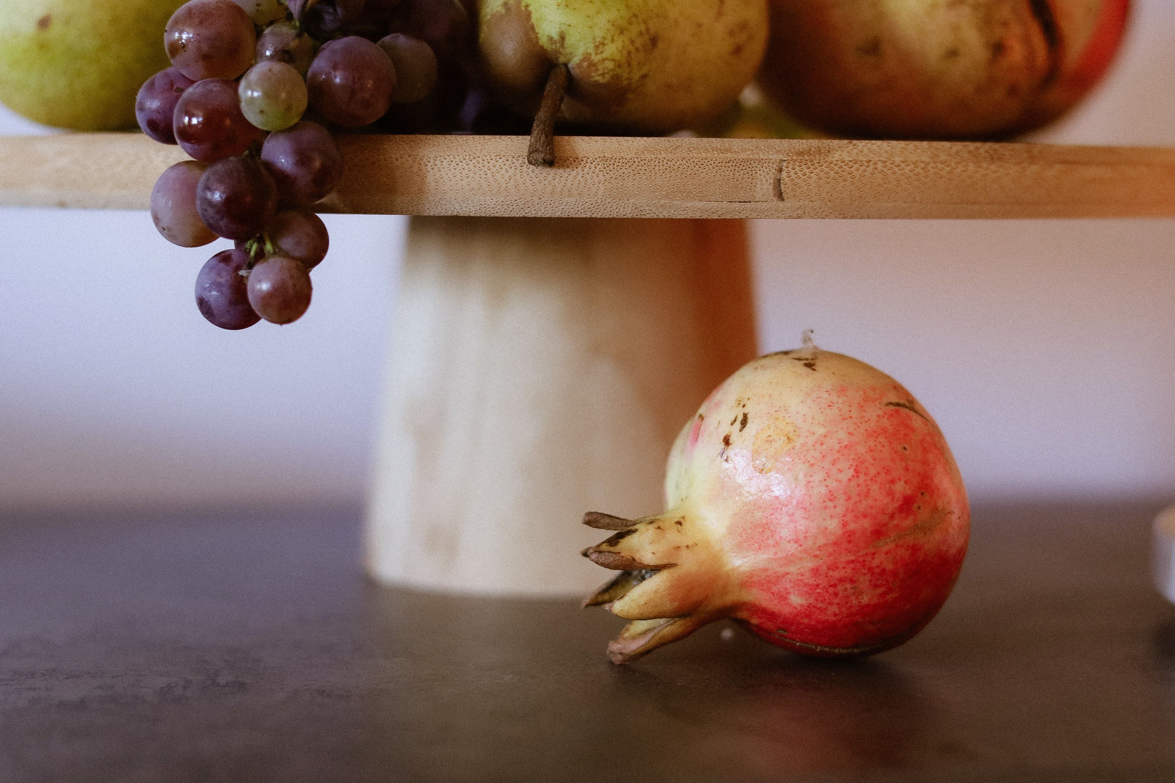 Vibrant Fruit Display with Pomegranate and Grapes · Free Stock Photo
