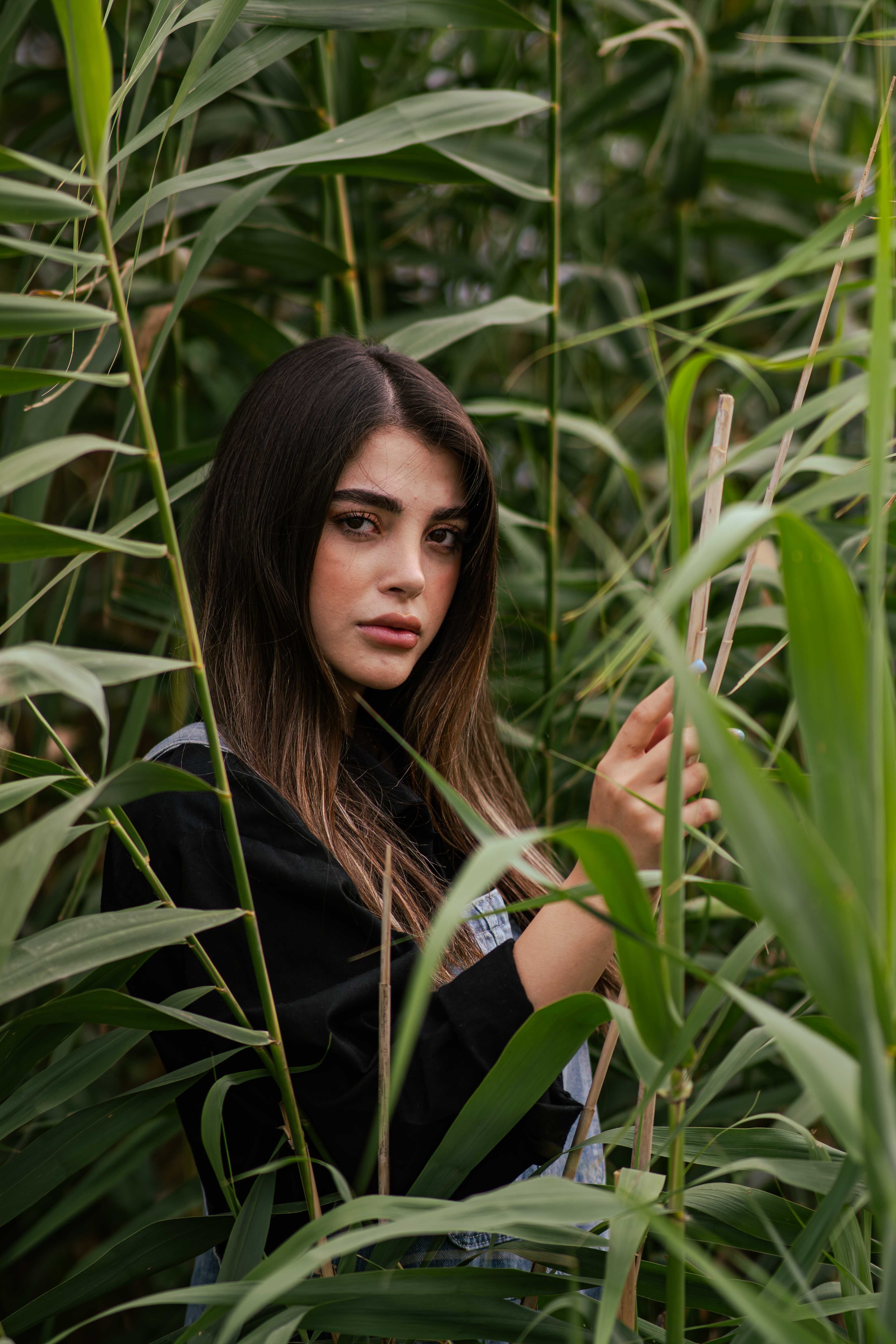 Portrait of a Woman in Lush Greenery Outdoors · Free Stock Photo