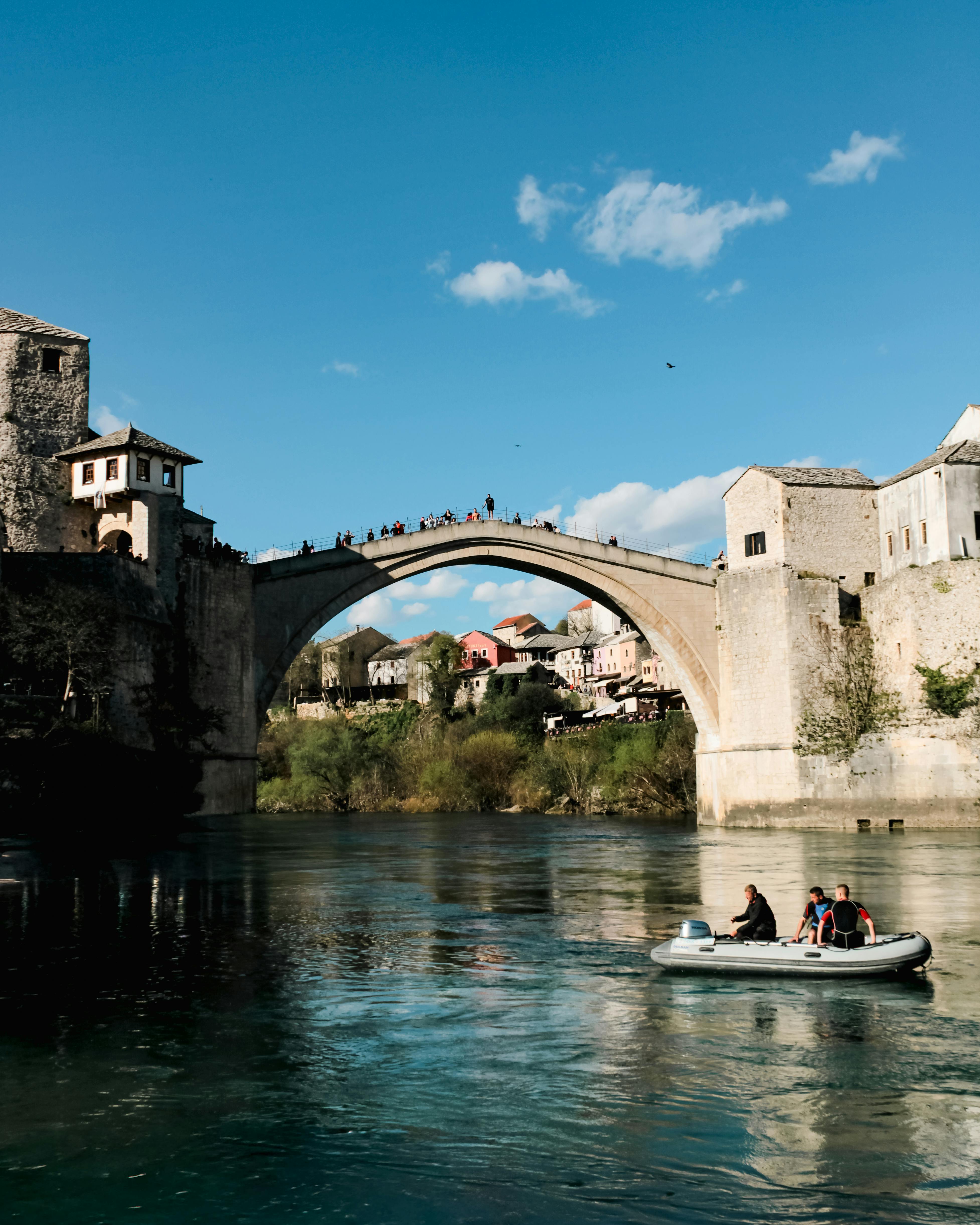 Old Bridge in Mostar with Boat on Neretva River · Free Stock Photo