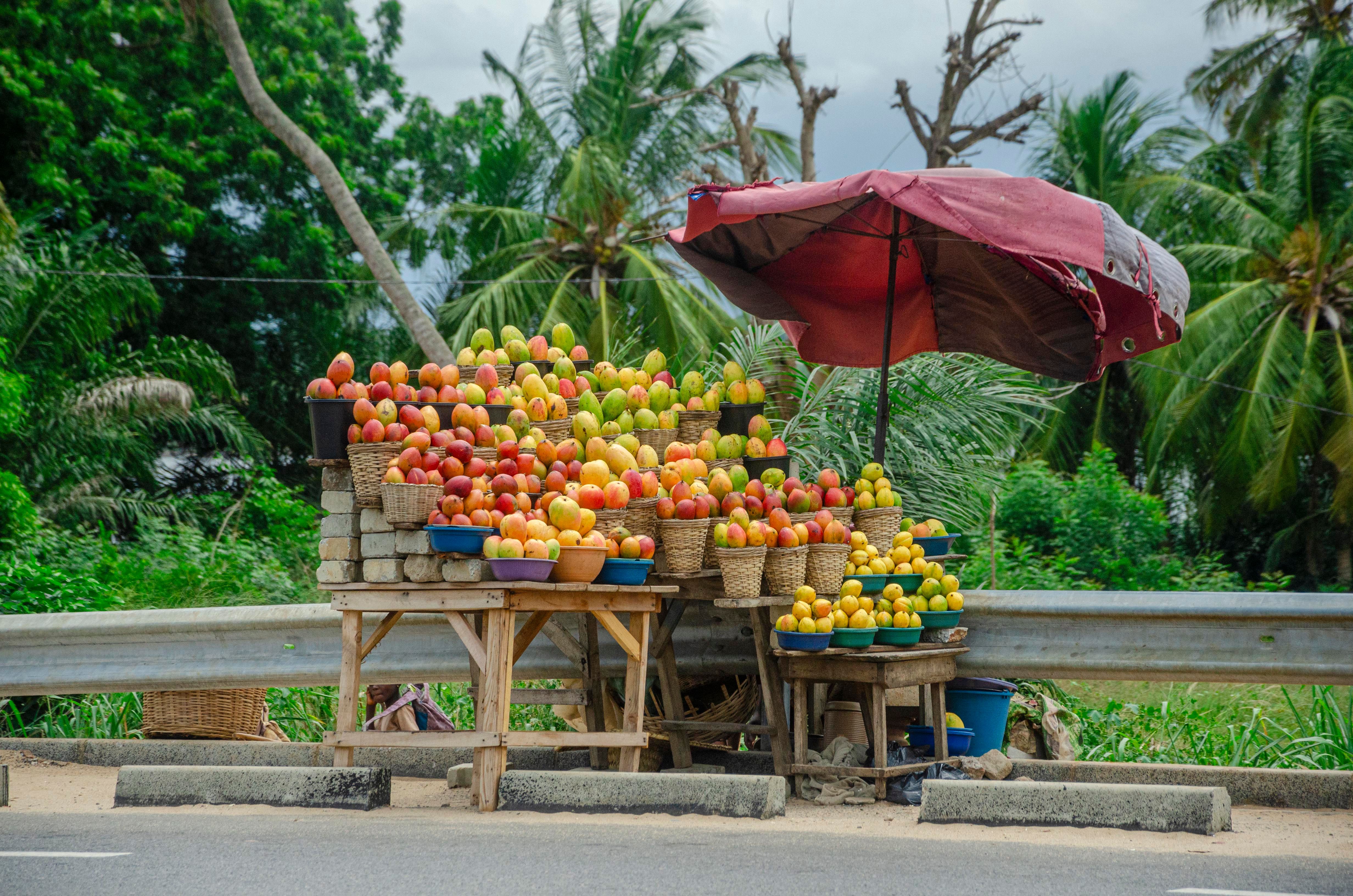 Vibrant Tropical Fruit Stall by the Roadside · Free Stock Photo