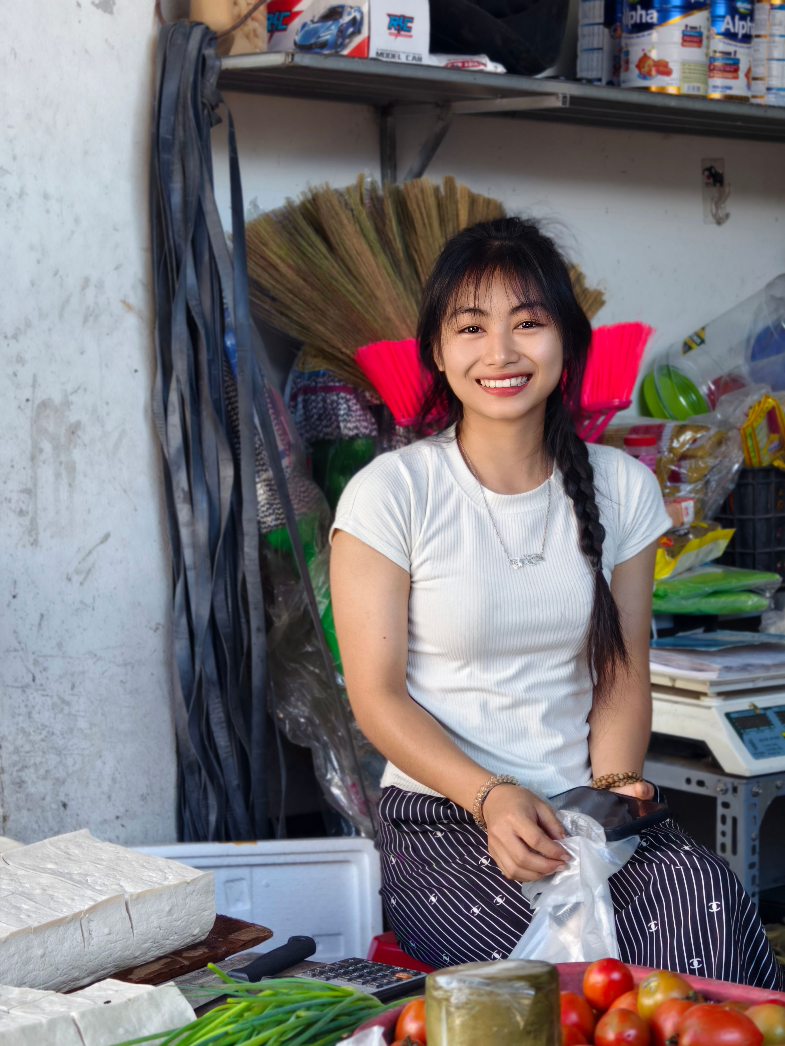 Smiling Woman at Market Stall with Fresh Produce · Free Stock Photo