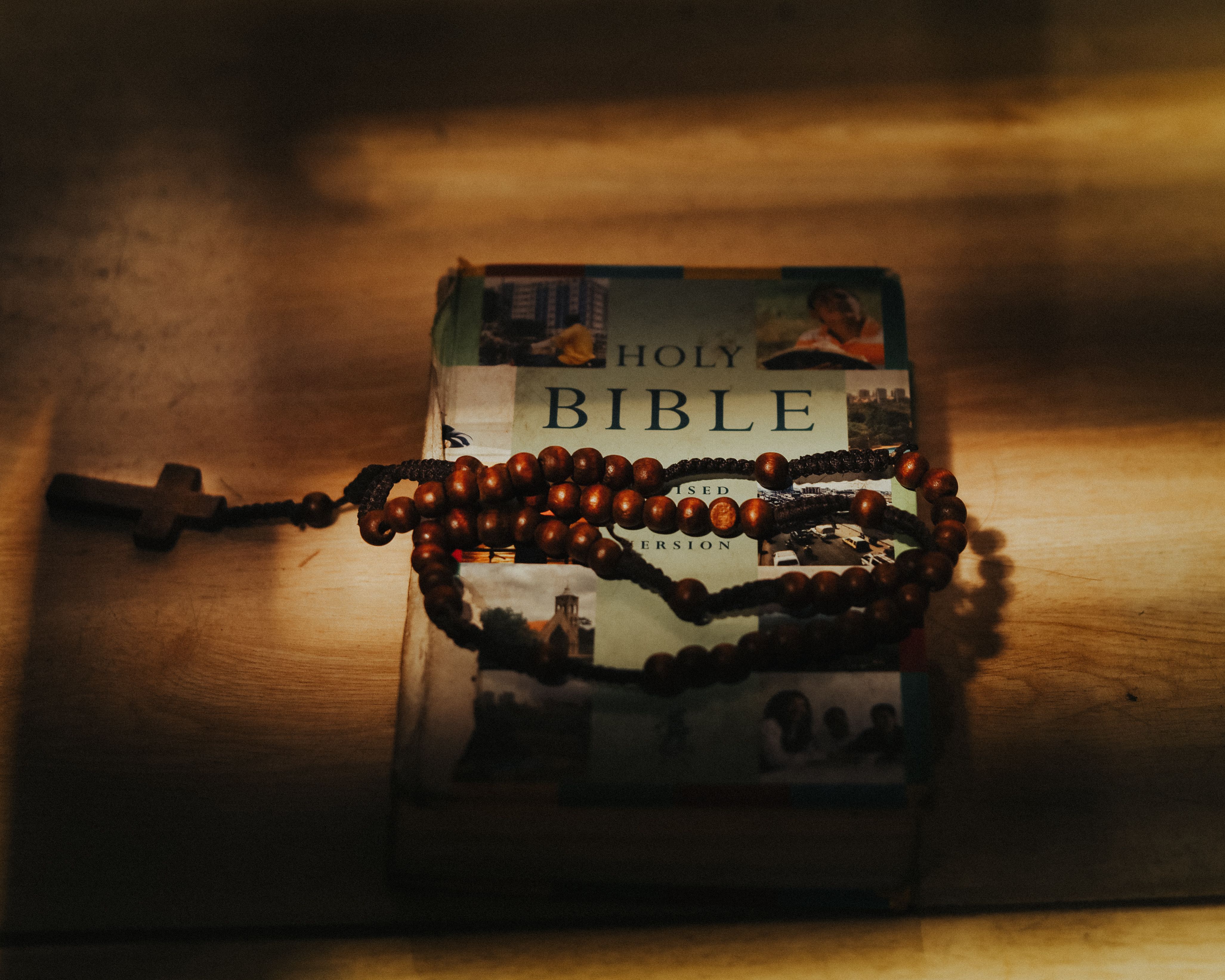 Bible with Rosary Beads in Warm Light · Free Stock Photo