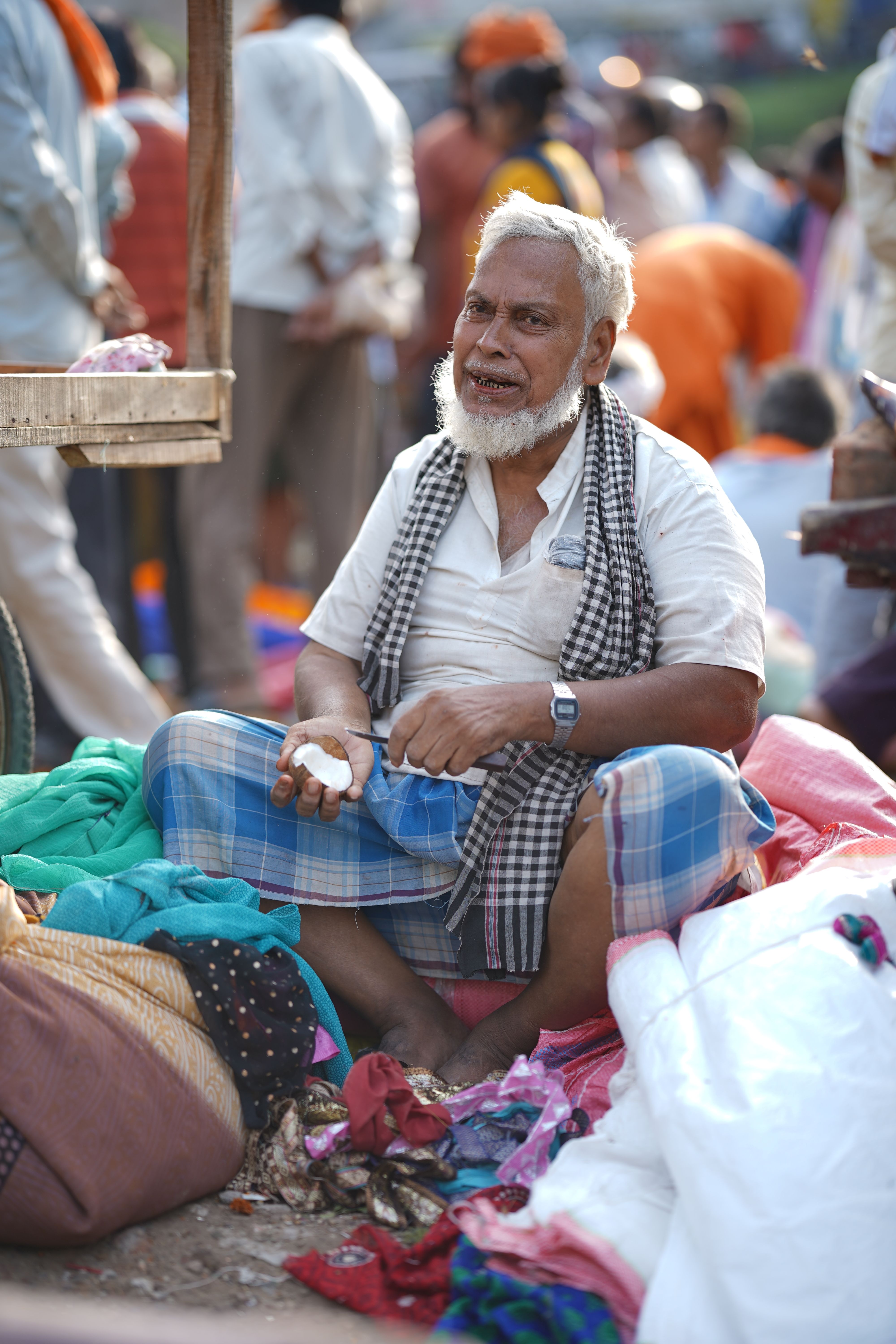 Elderly Man Selling Fabrics in Busy Outdoor Market · Free Stock Photo
